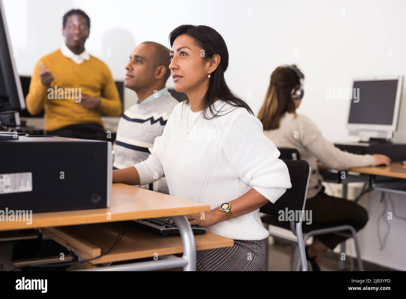Young adult woman studying in computer class Stock Photo - Alamy