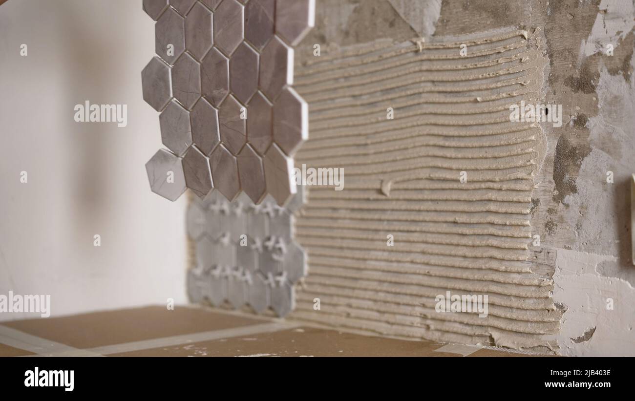 The process of applying plaster adhesive for ceramic tiles. The tile is ...
