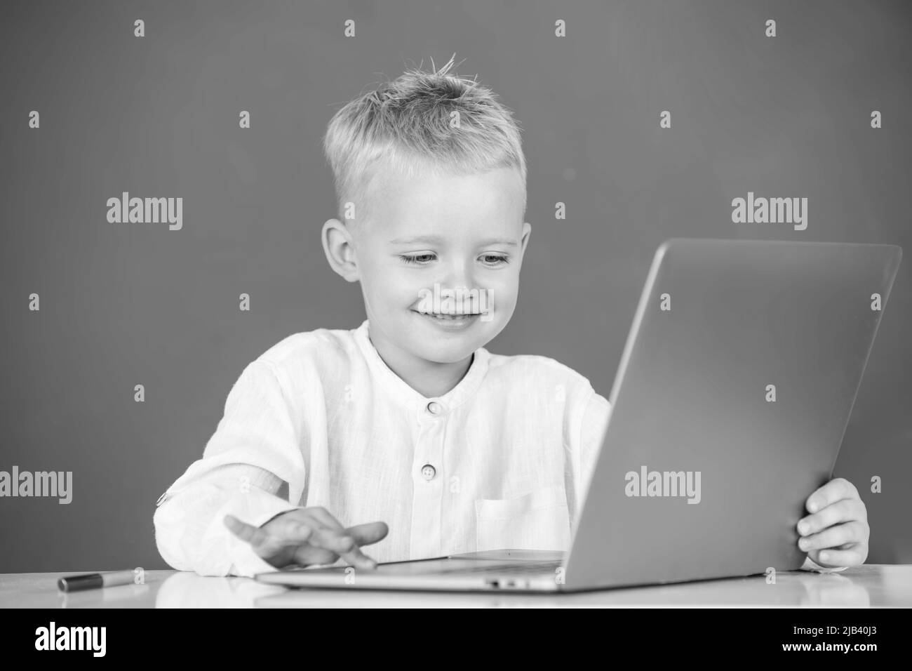 Cute smiling child using laptop computer, kid boy studying through ...