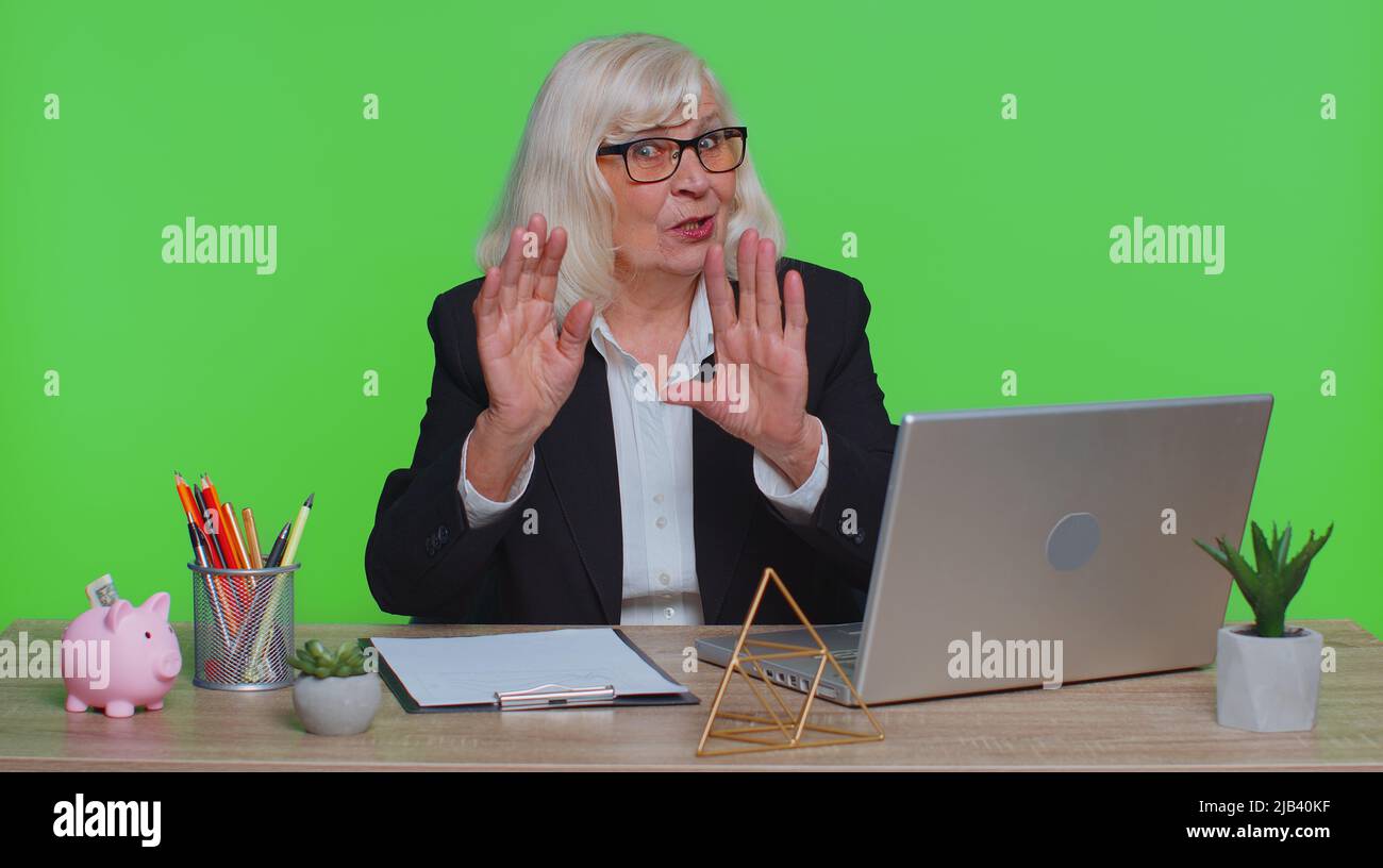 Hello. Senior business woman employee wears glasses waves hand palm in ...