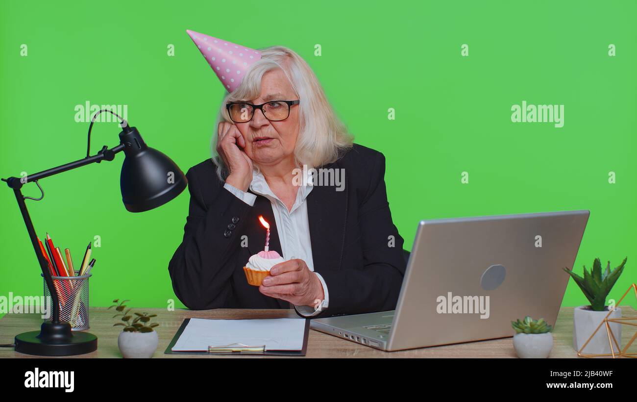 Senior mature businesswoman celebrating lonely birthday in office ...