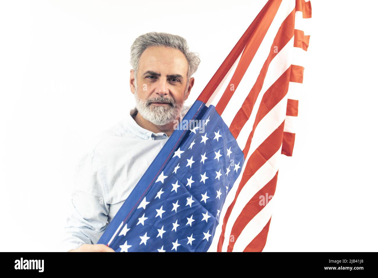 Proud American man in his 50s hiding behind the flag of United States ...