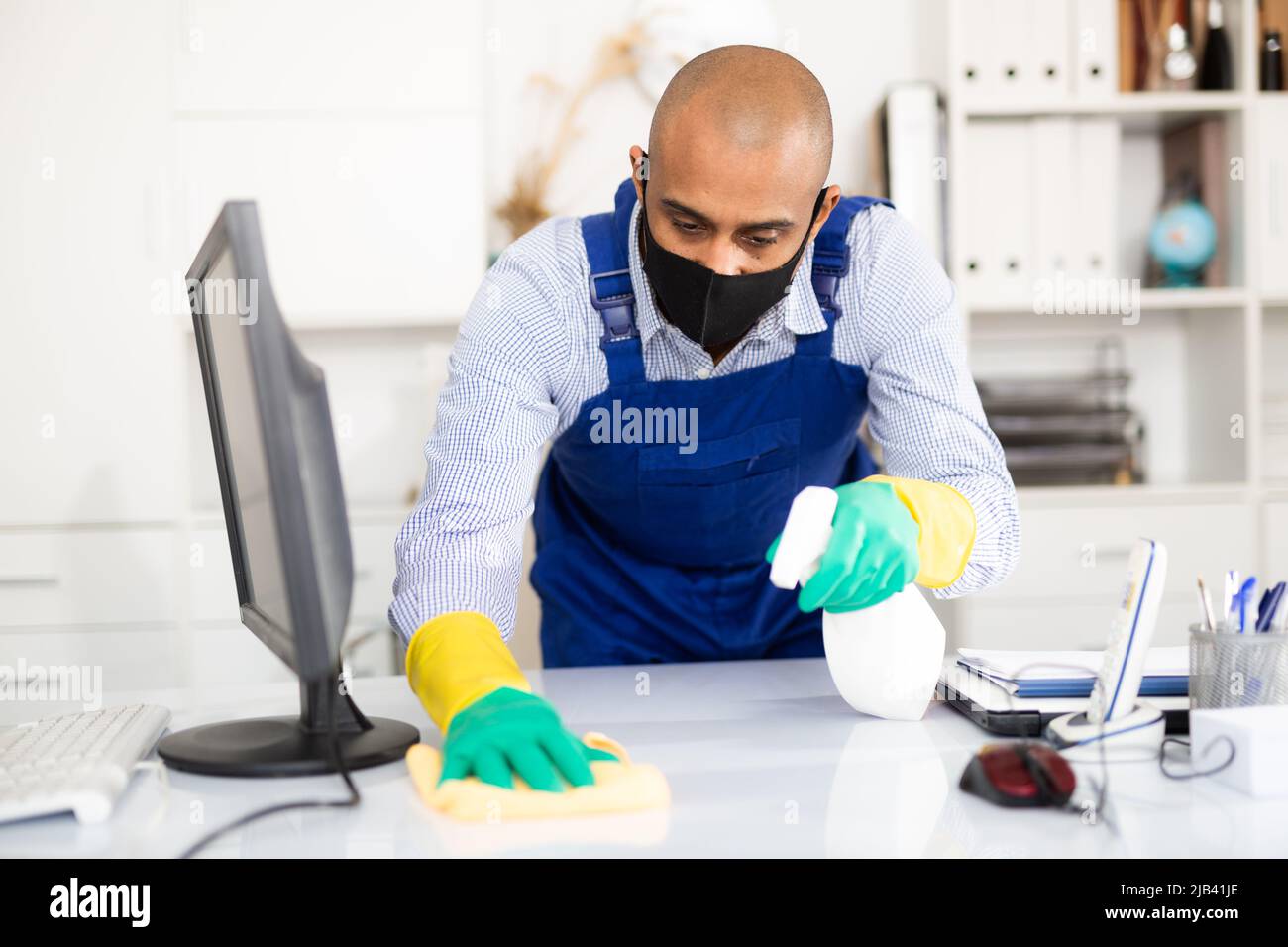 Professional cleaner sanitize work desk in office with cleaning ...