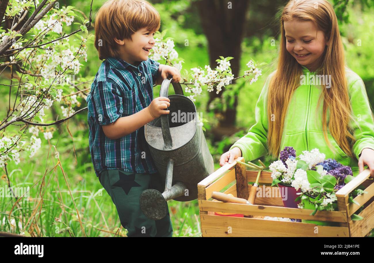 Little toddler boy and girl gardening and having fun in spring yard ...