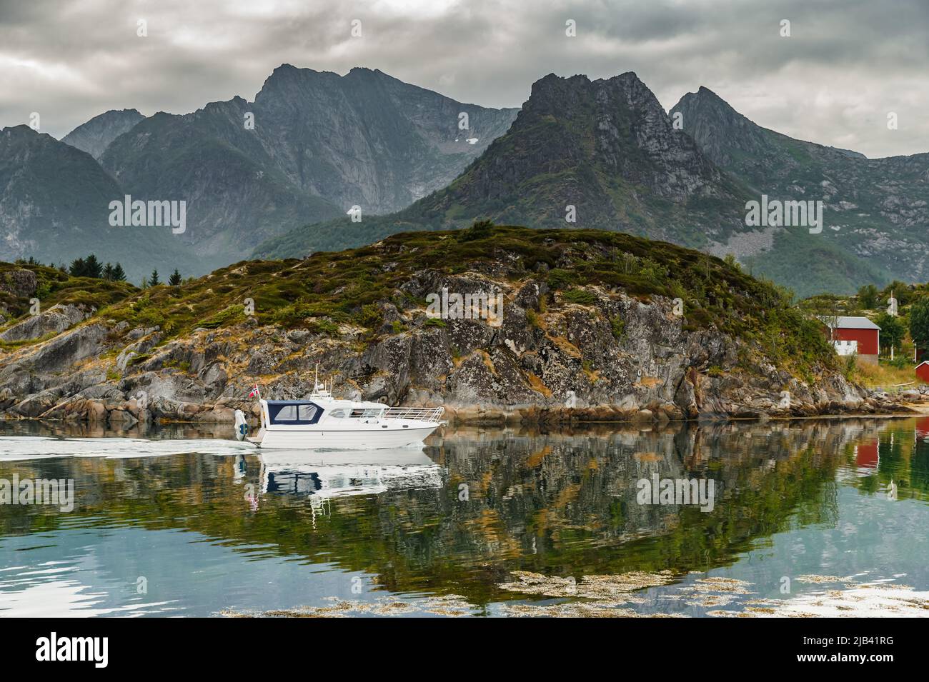 a small white fishing boat floats through the water along the rocks ...