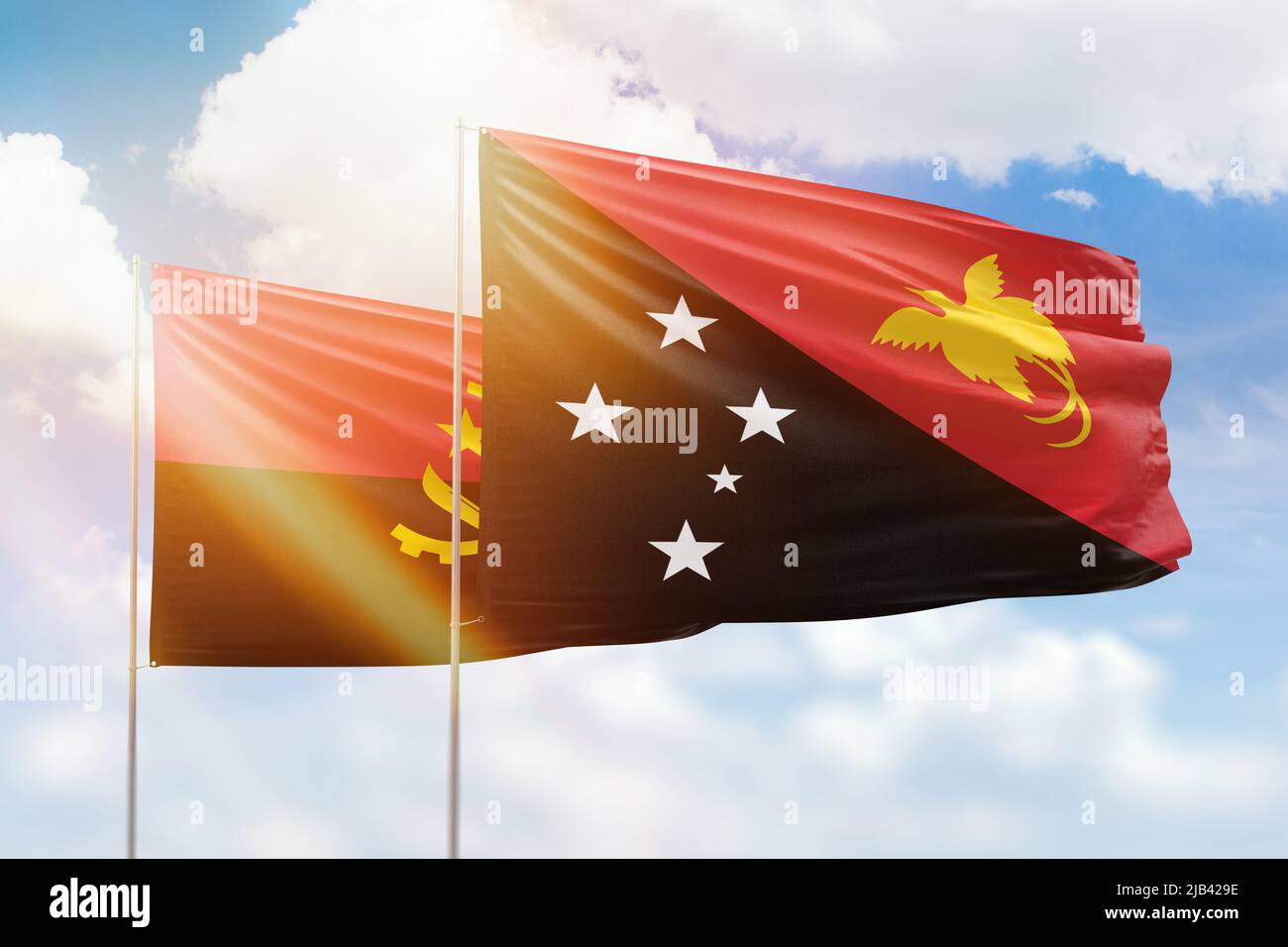 Sunny blue sky and flags of papua new guinea and angola Stock Photo - Alamy