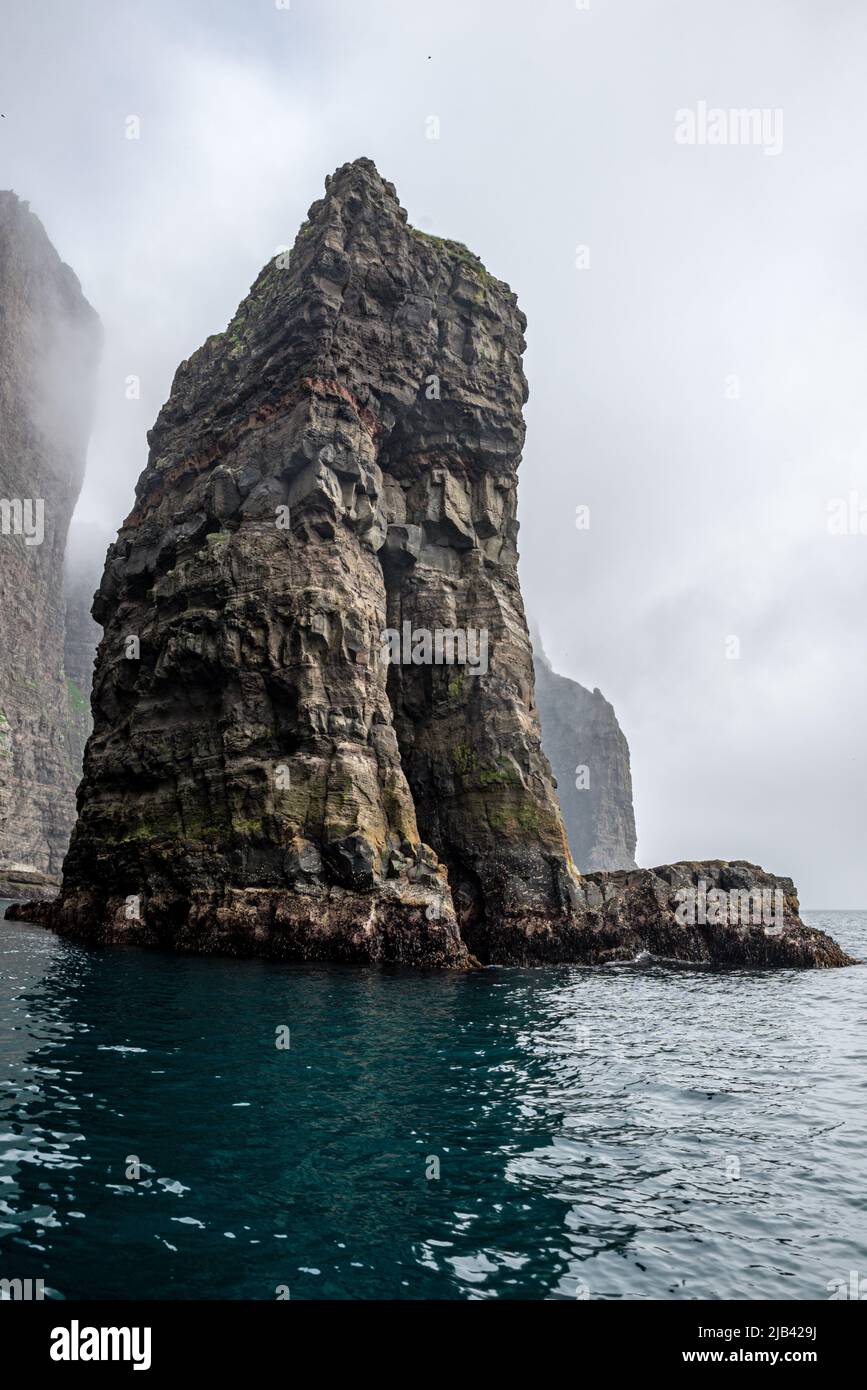 A steep sea stack close to Drangarnir rock formation on Vagar Island ...