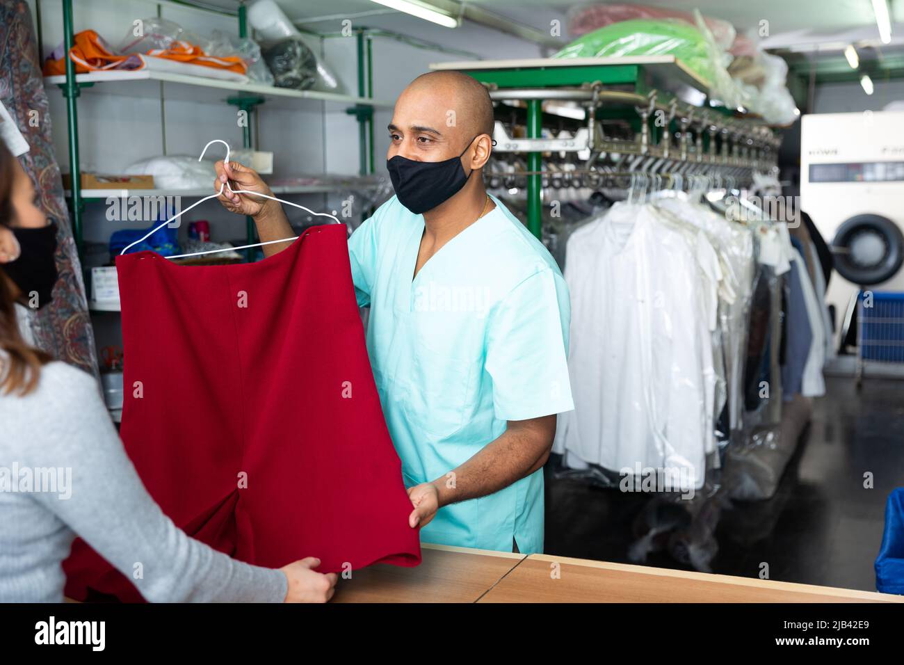 Man dry-cleaning worker giving clothes to customer Stock Photo - Alamy