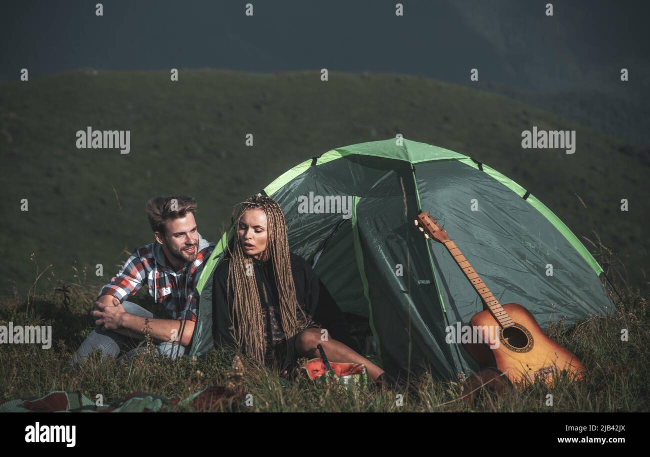 Traveling man and woman have a nice time resting in mountains. Active ...