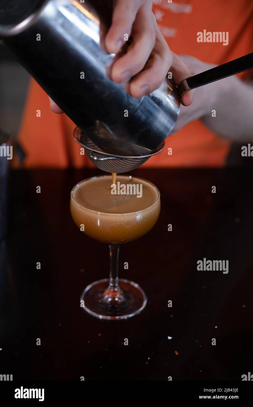 Barman is making cocktail at night club. stylish young man mixing a ...