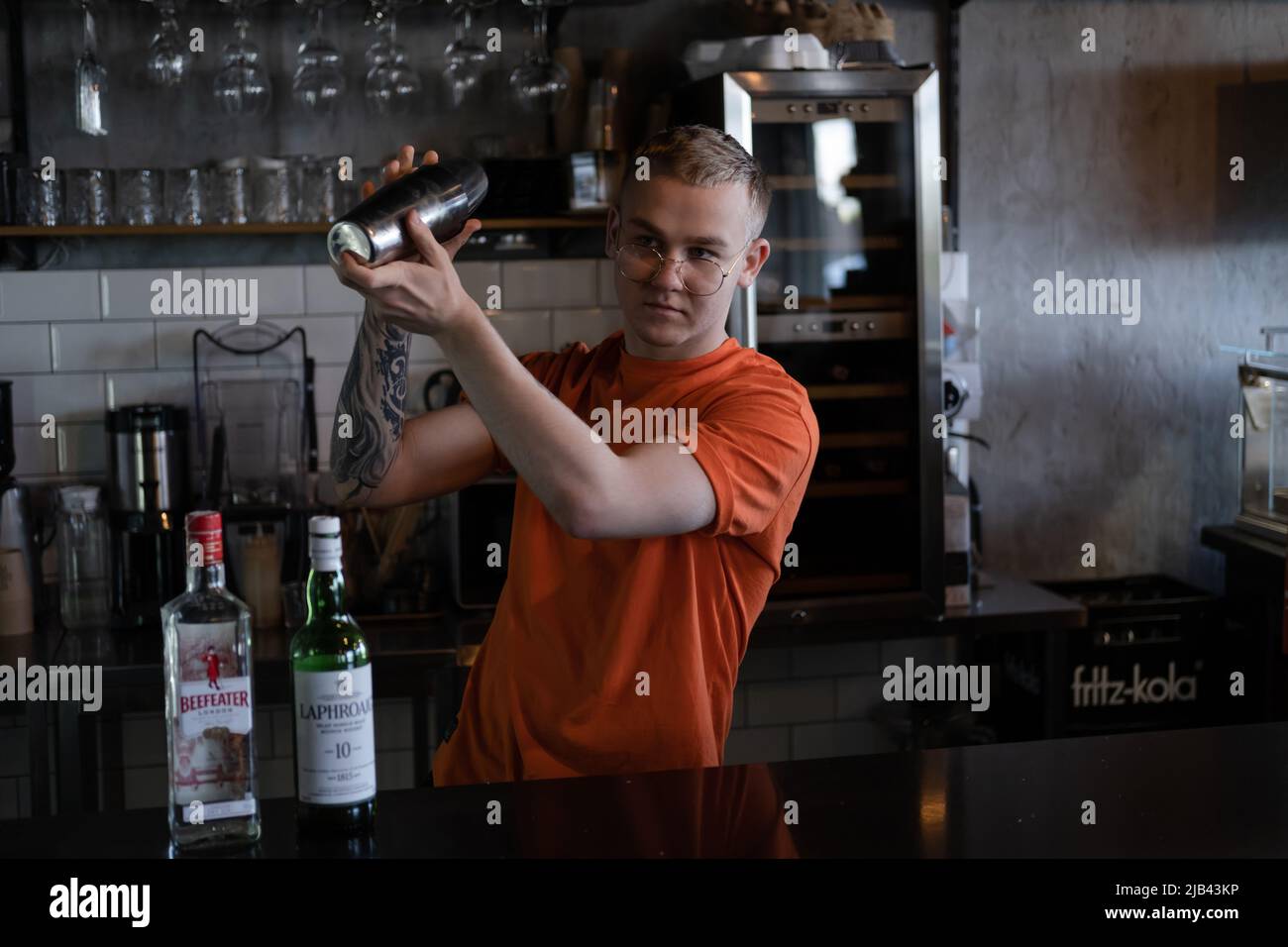 Barman is making cocktail at night club. stylish young man mixing a ...