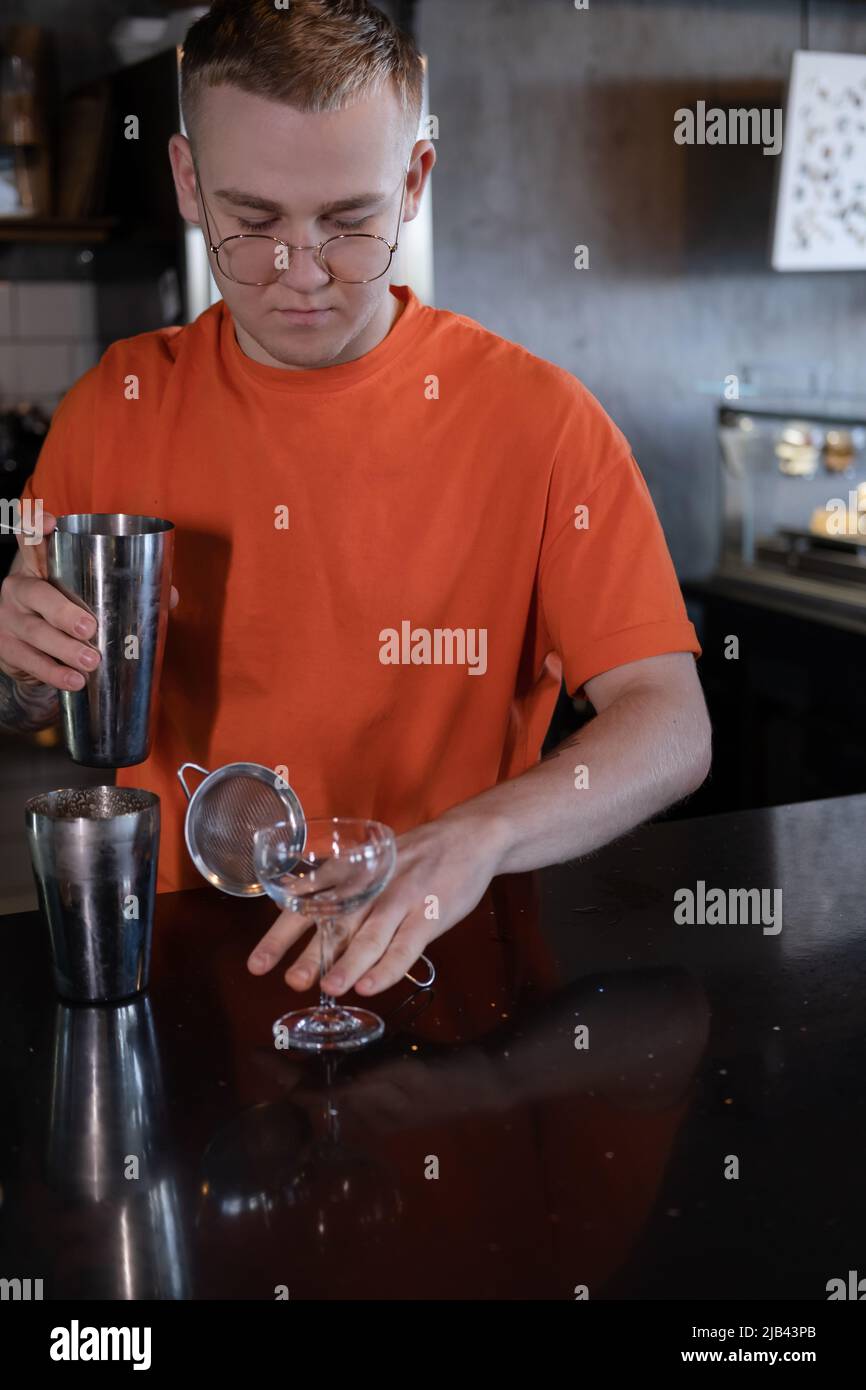 Barman is making cocktail at night club. stylish young man mixing a ...