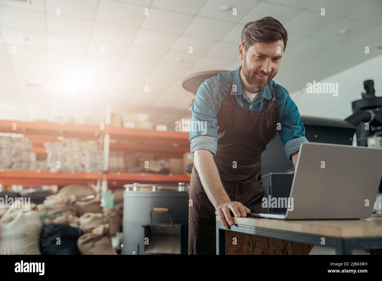 Business owner of small coffee factory working laptop on background of ...