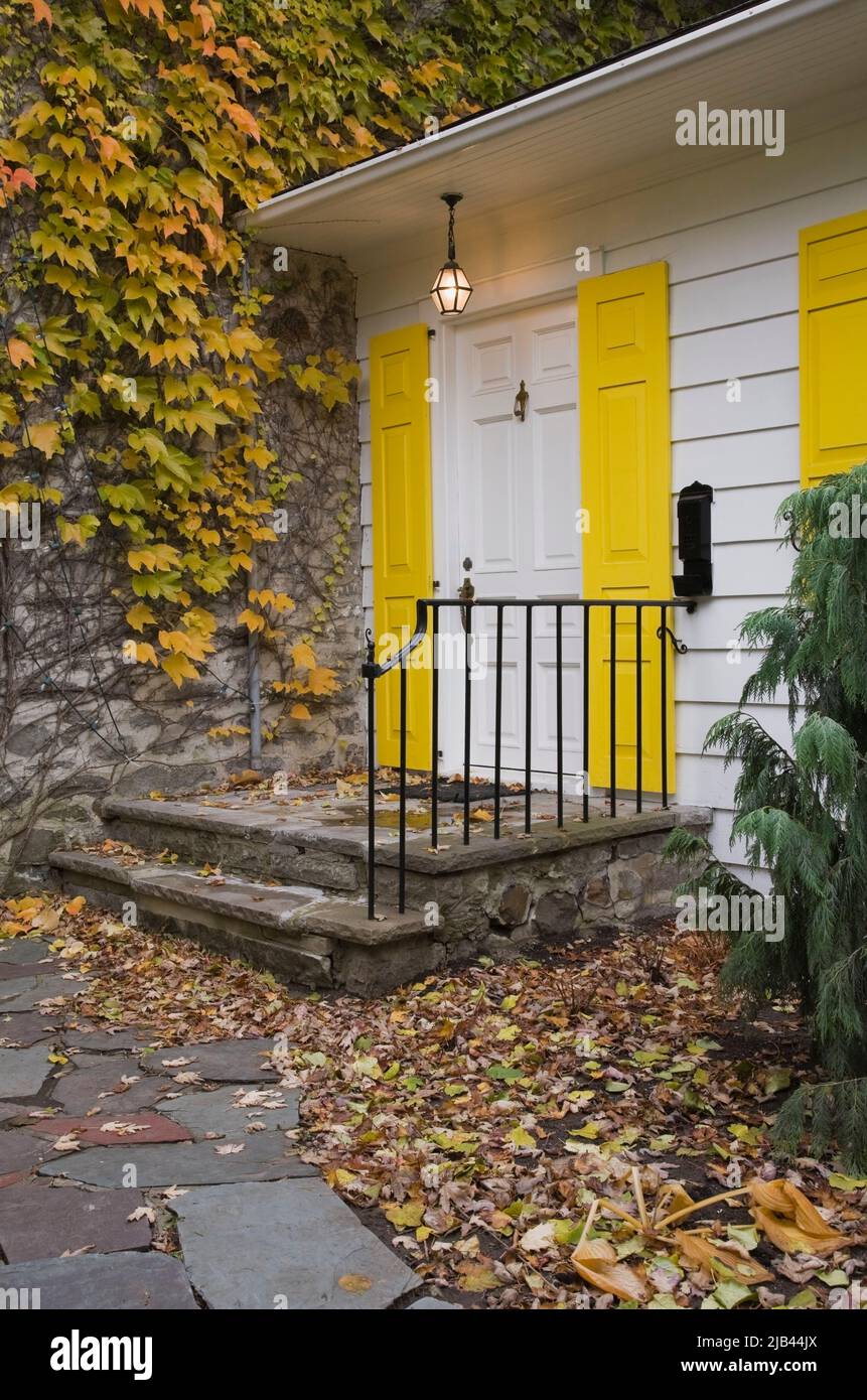 Old circa 1834 fieldstone home with white wood plank cladding and ...