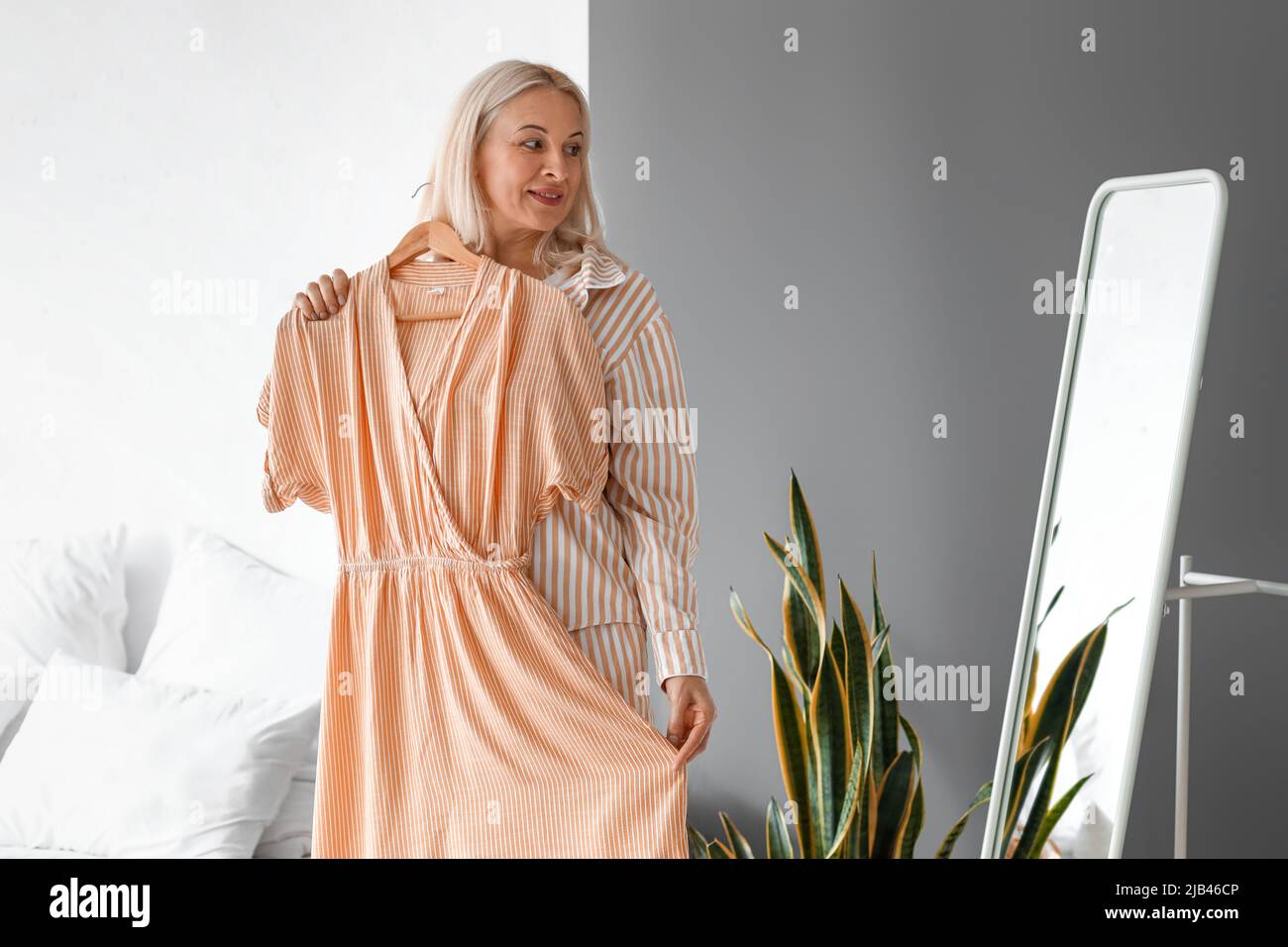 Mature woman looking in mirror clothes hi-res stock photography and ...