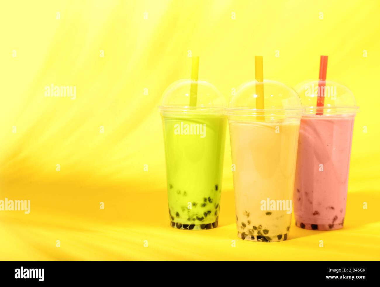Plastic cups of different tasty bubble tea on yellow background Stock ...