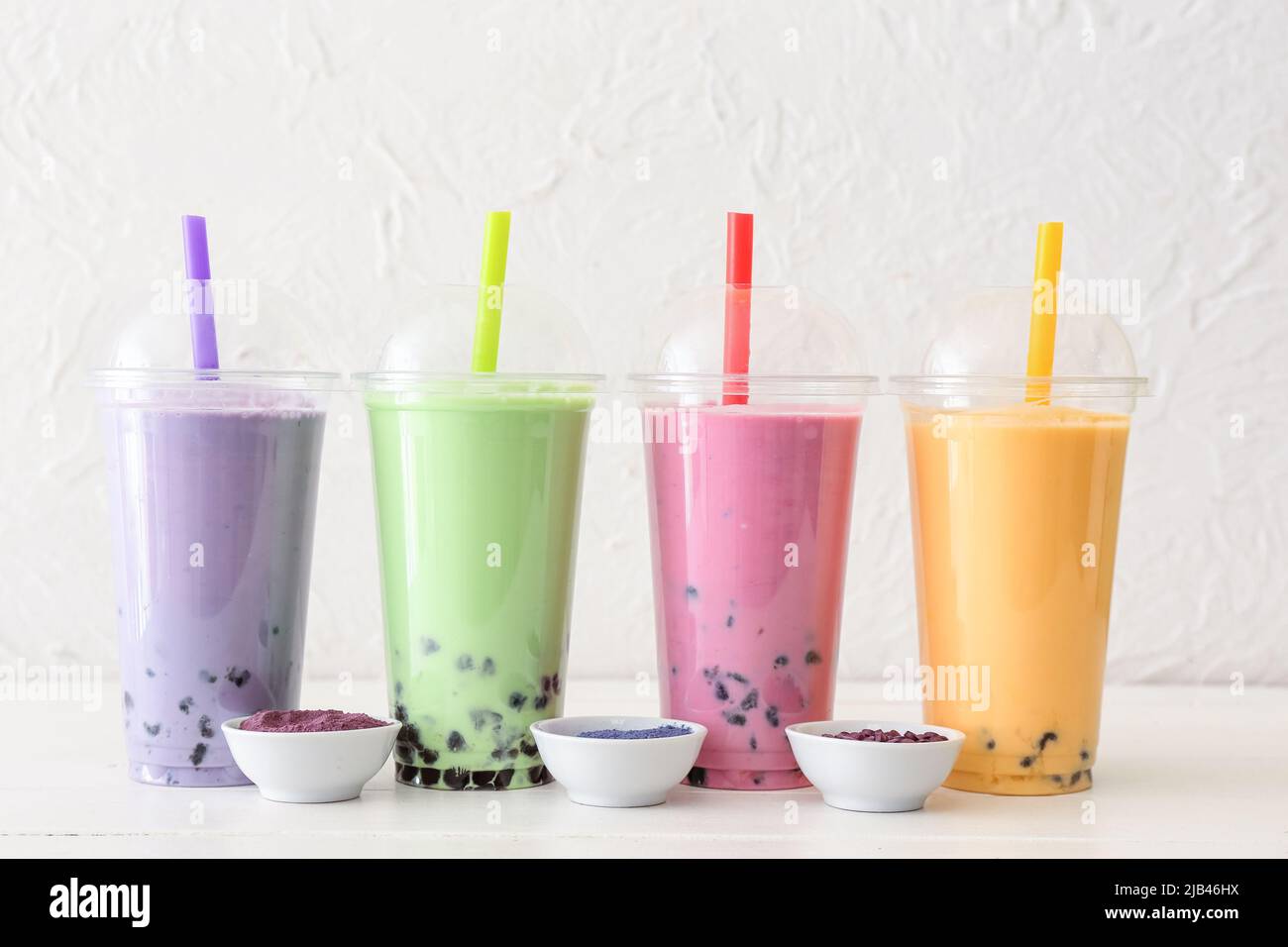Plastic cups of different tasty bubble tea on table Stock Photo - Alamy