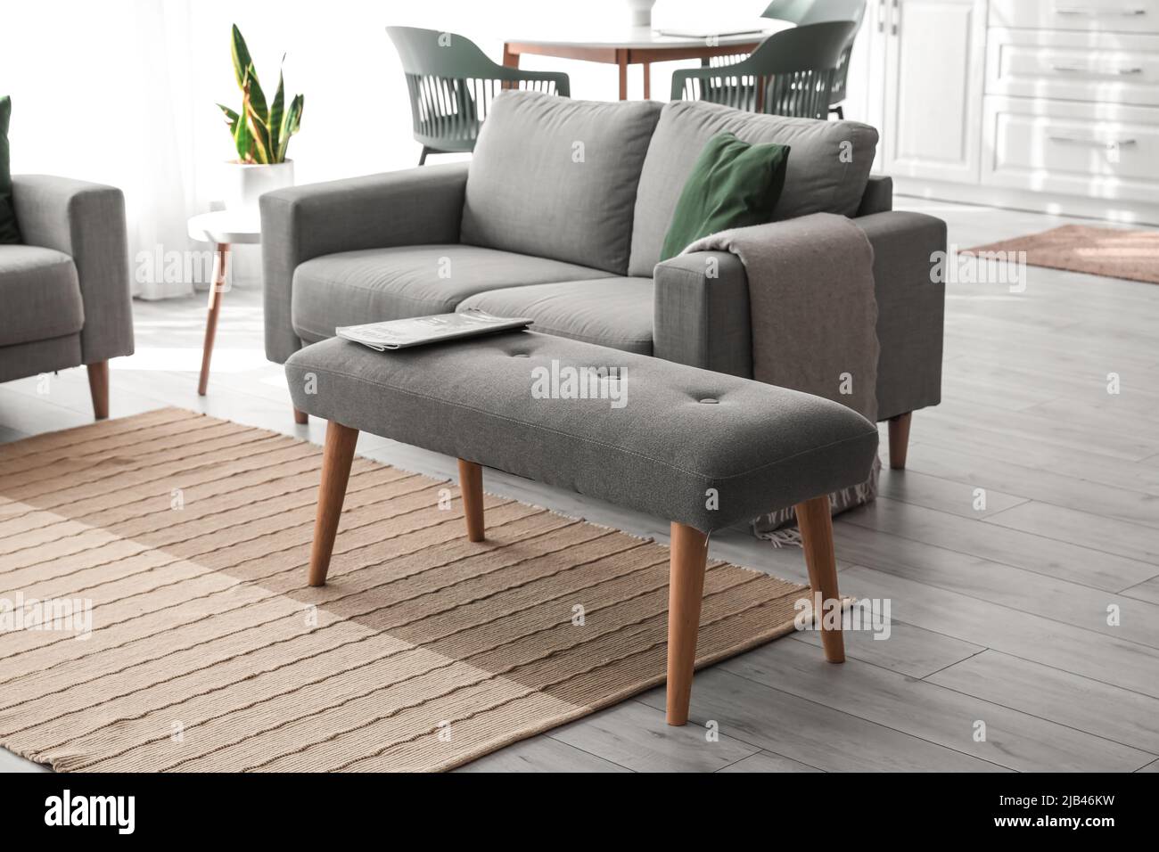 Soft bench with magazines near sofa in modern room Stock Photo - Alamy