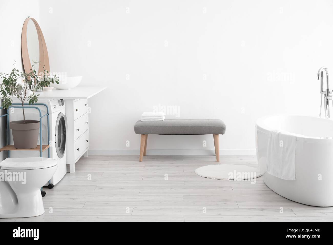 Interior of light bathroom with soft bench and washing machine Stock ...