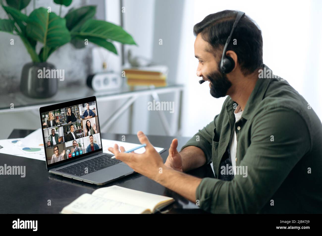 Successful busy mixed race successful man, sitting at work desk in ...