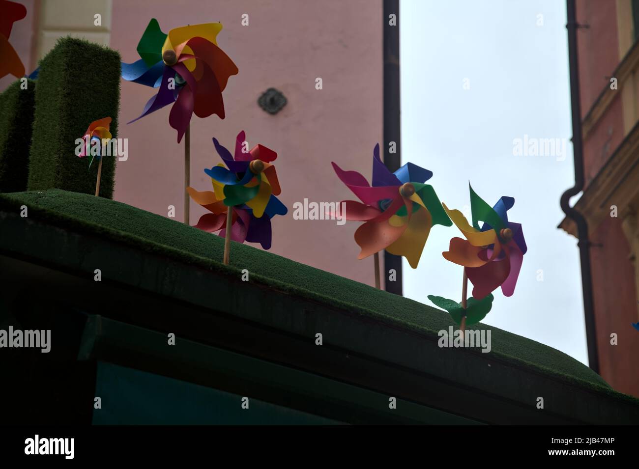 Pinwheels on a roof with two buildings in the backdrop on a rainy day ...