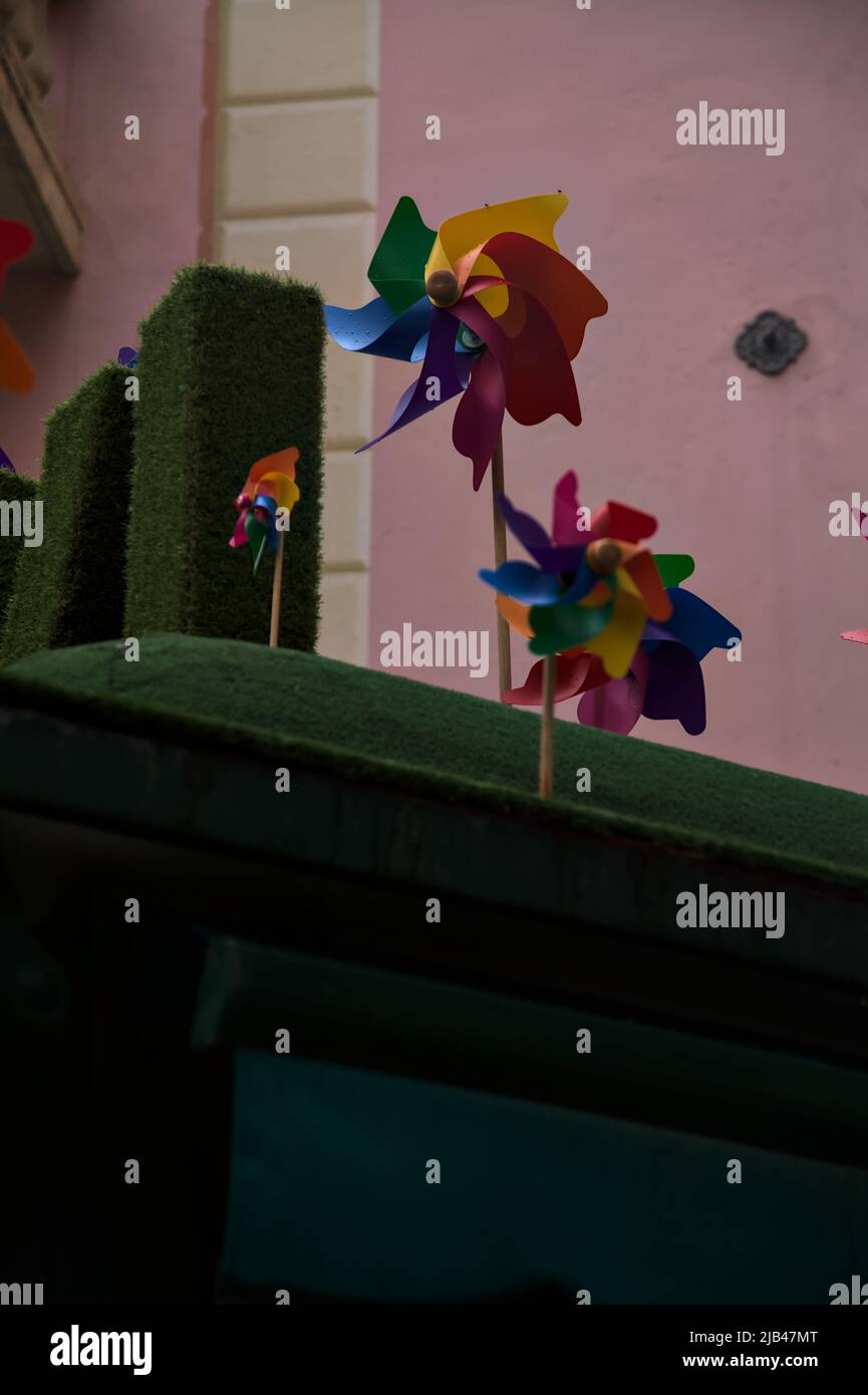 Pinwheels on a roof with two buildings in the backdrop on a rainy day ...