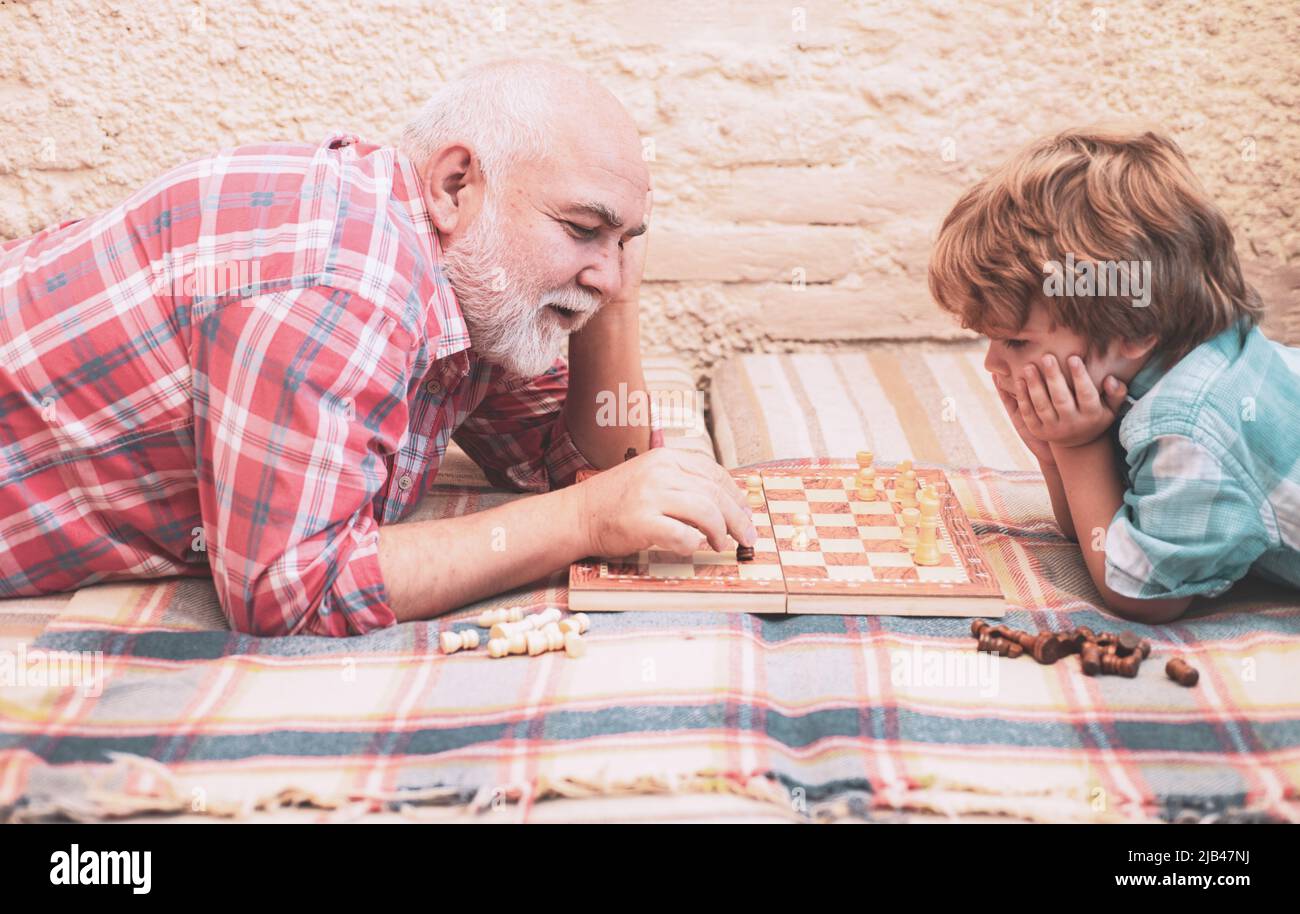 Kid Playing Chess. Grandfather and grandson are playing chess and ...