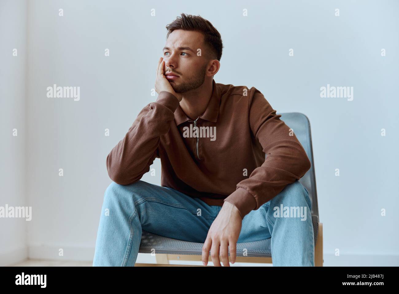 Upset frustrated thoughtful pensive serious young man reclines on hand ...
