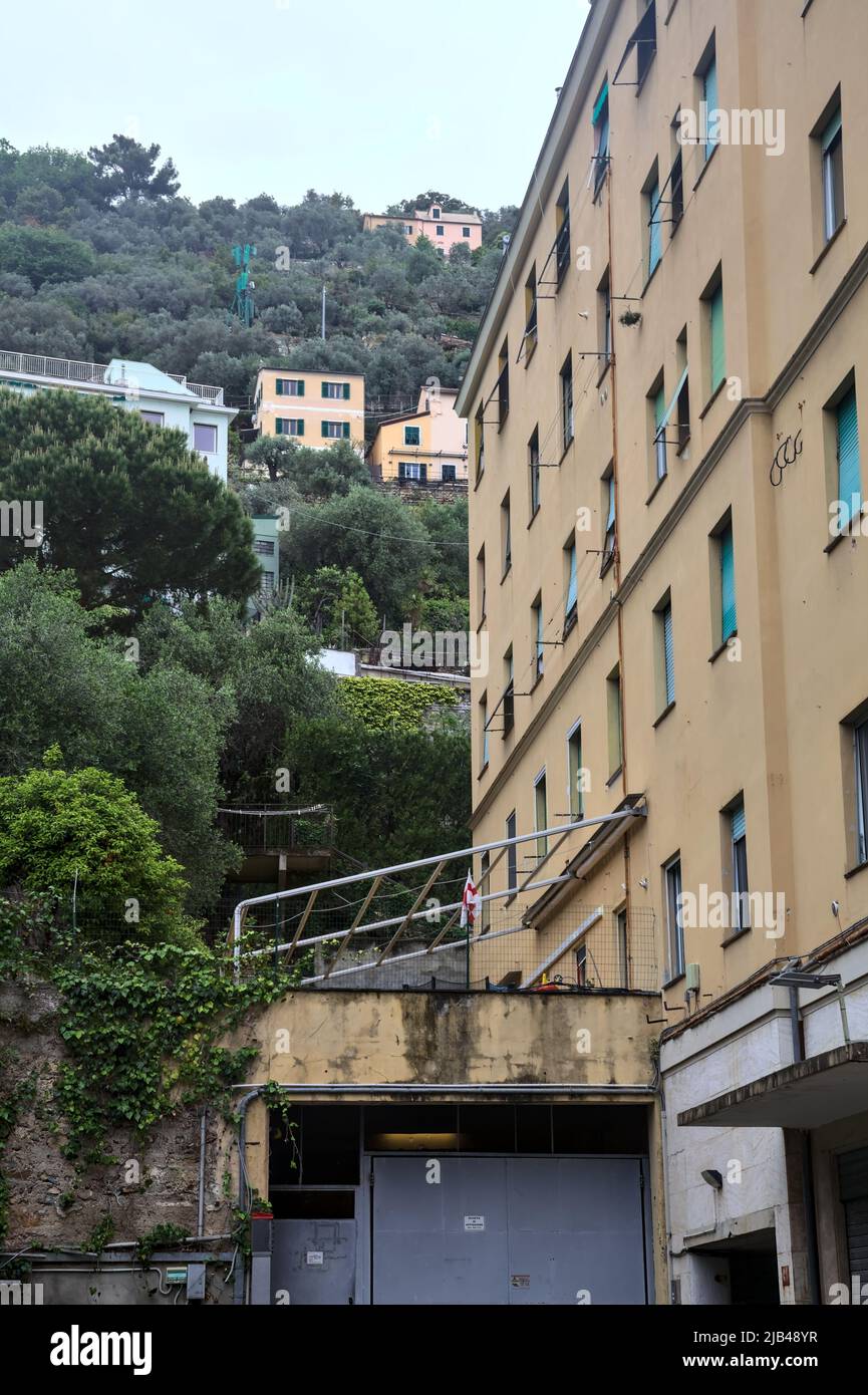 Houses on a cliff with trees framed by the facade of a modern ...