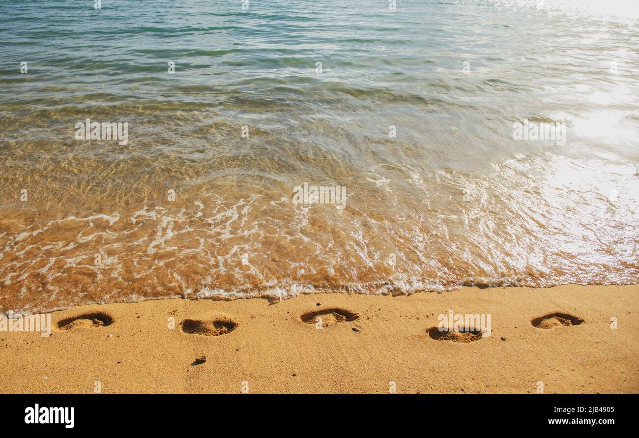 Footprints at golden sand, footsteps. Tropical beach with sea sand on ...