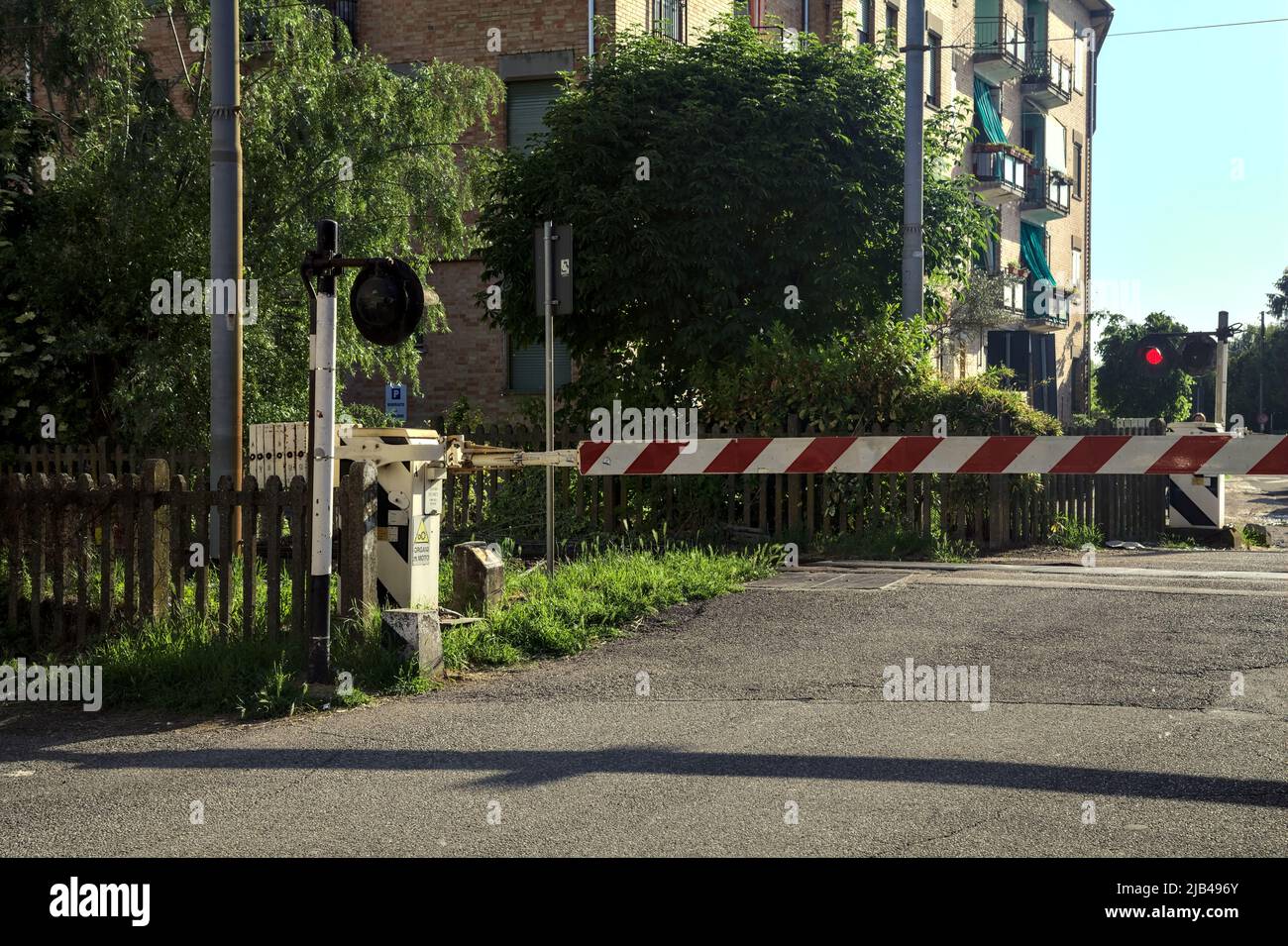Railroad crossing with lowered bars at sunset Stock Photo - Alamy