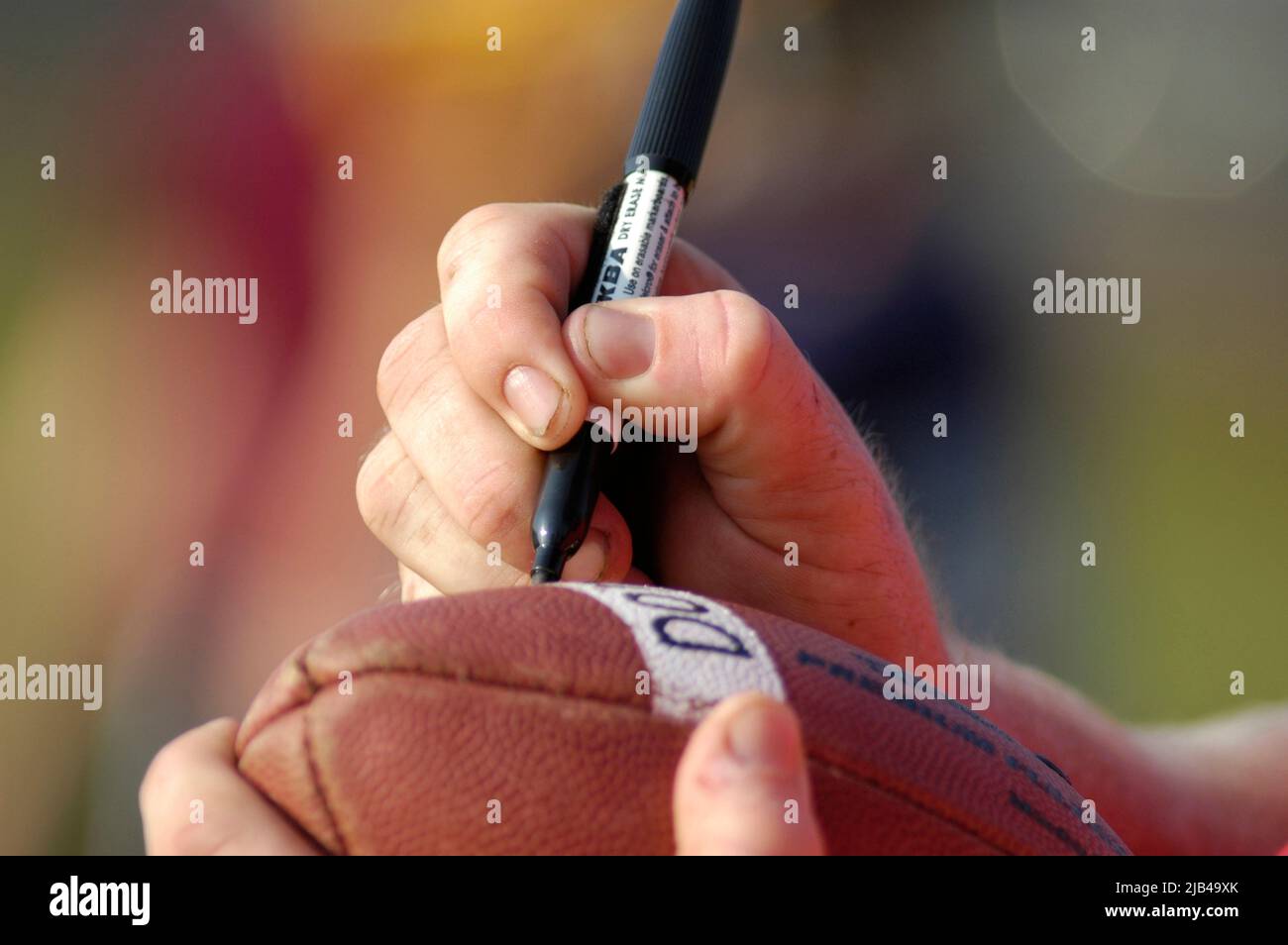 Putting name on football for ID before practice with hand lettering ...