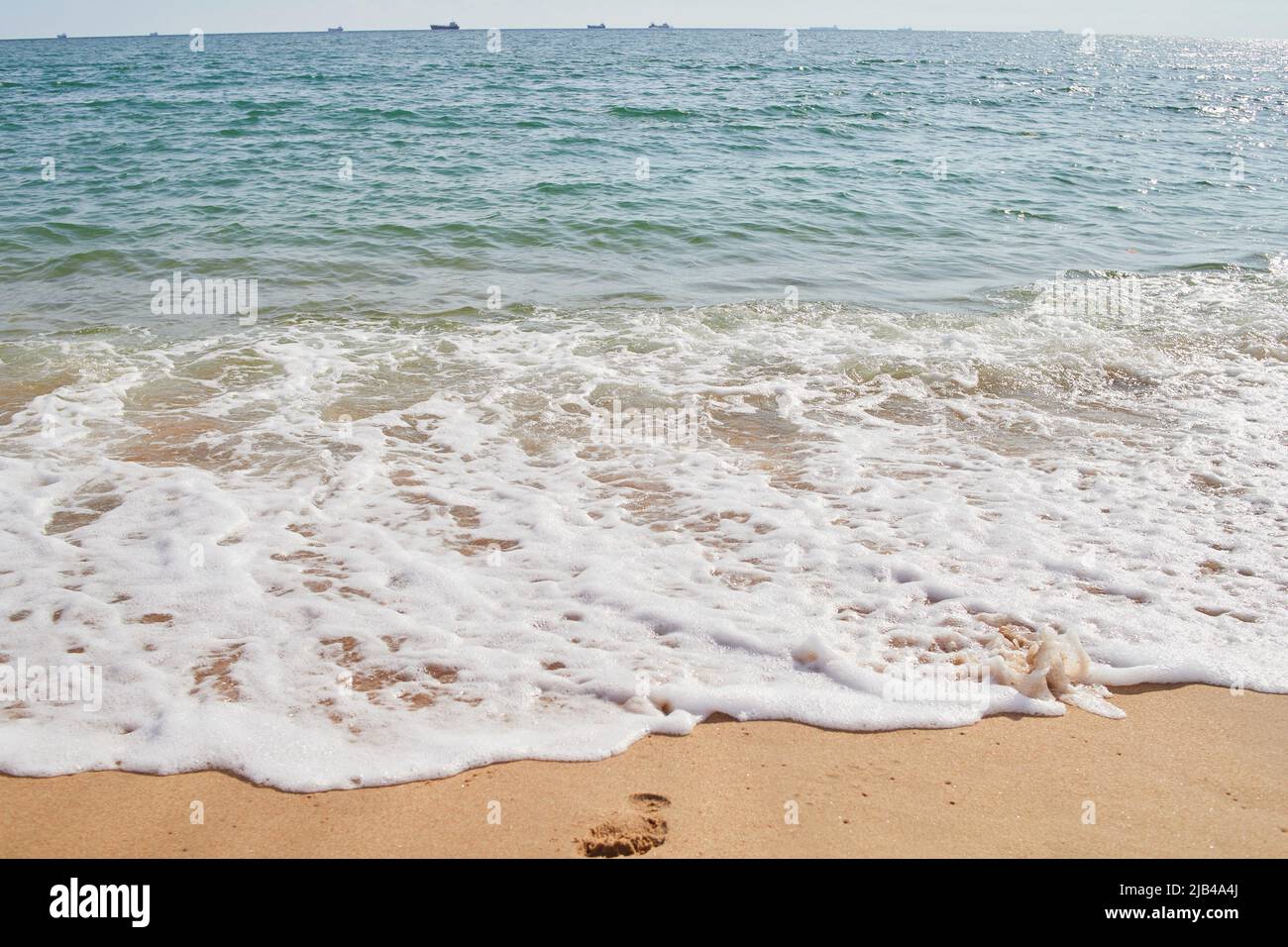 sand and beach with frothy wave Stock Photo - Alamy