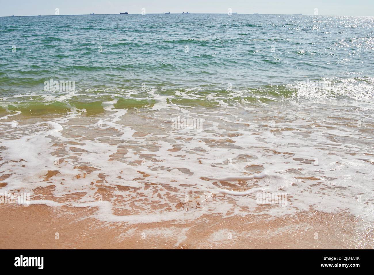 sand and beach with frothy wave Stock Photo - Alamy
