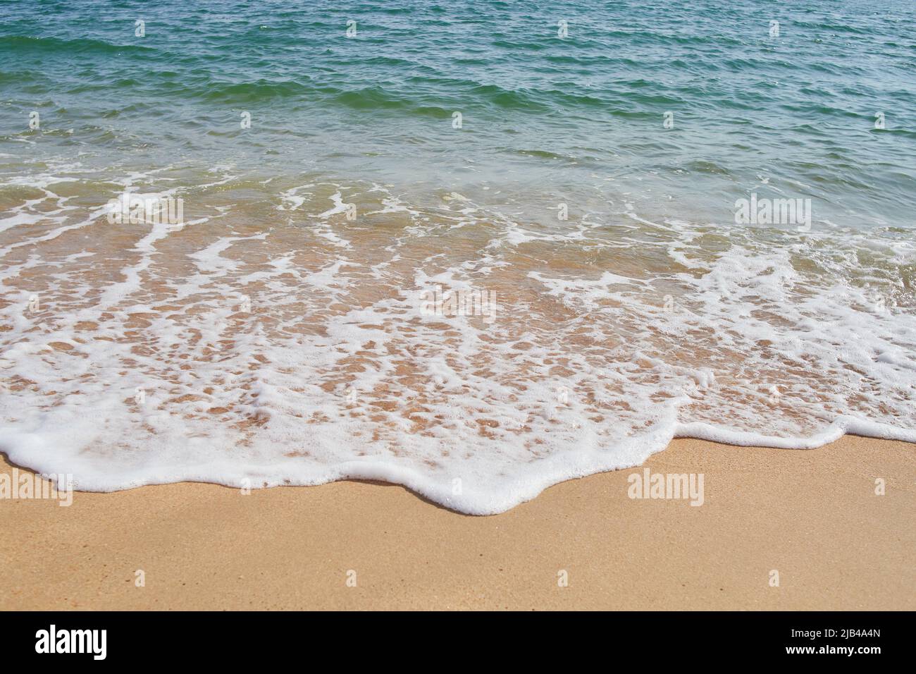 sand and beach with frothy wave Stock Photo - Alamy