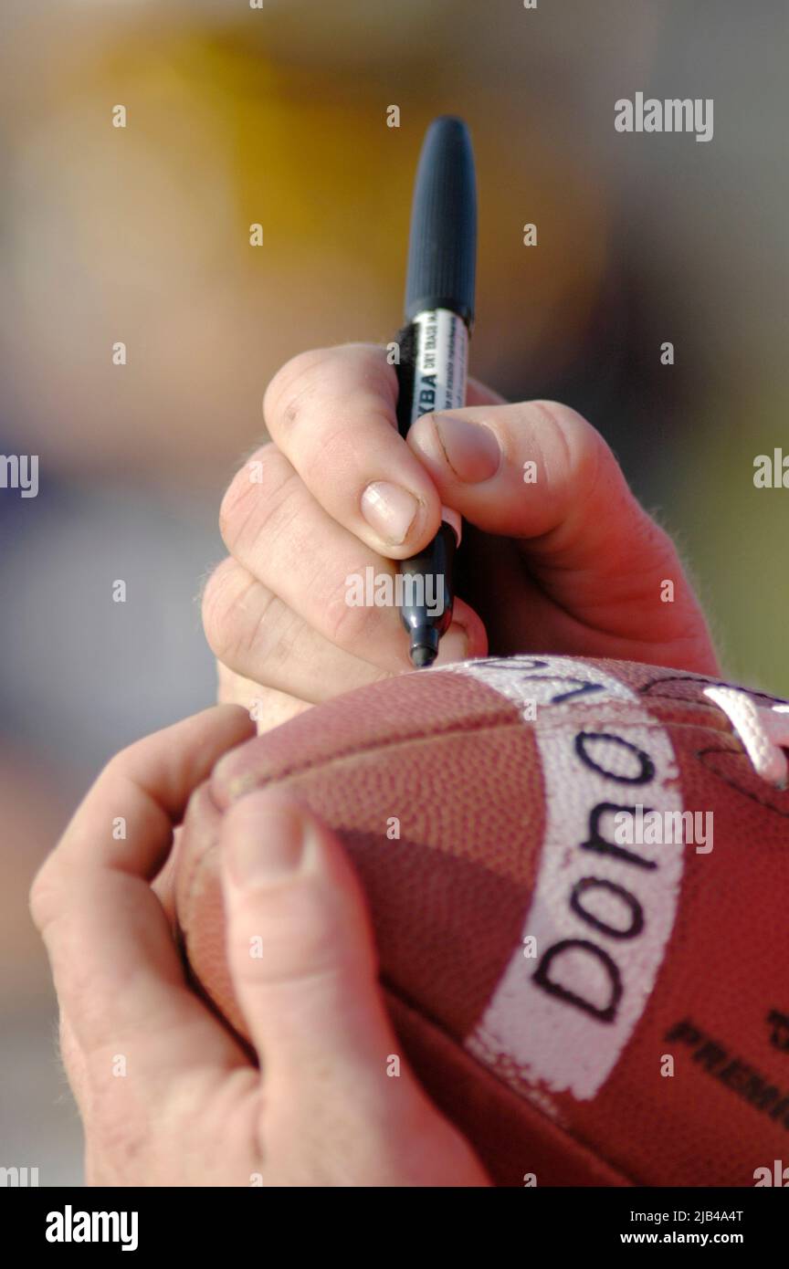 Putting name on football for ID before practice with hand lettering ...