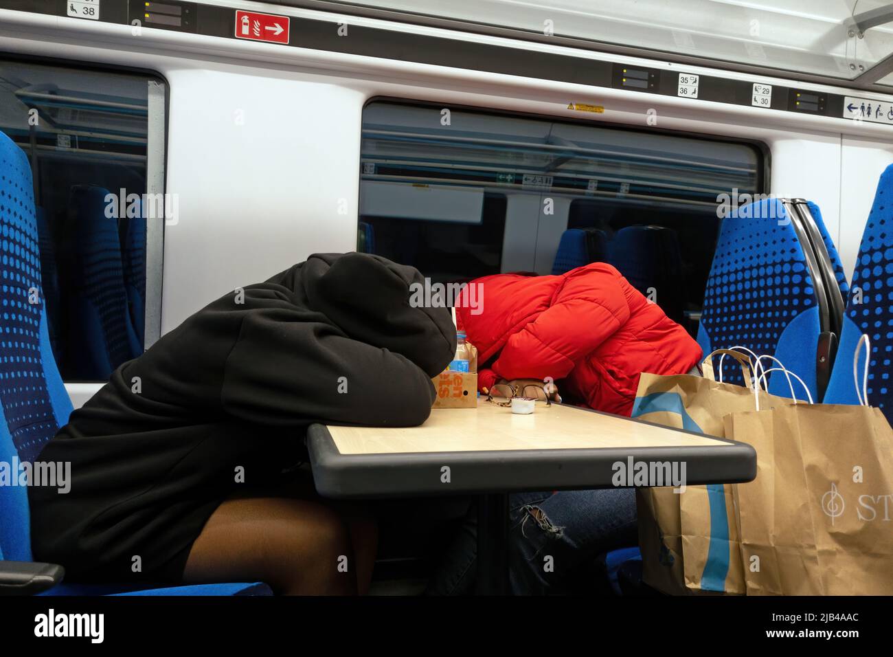 two young people sleeping on a train Stock Photo - Alamy