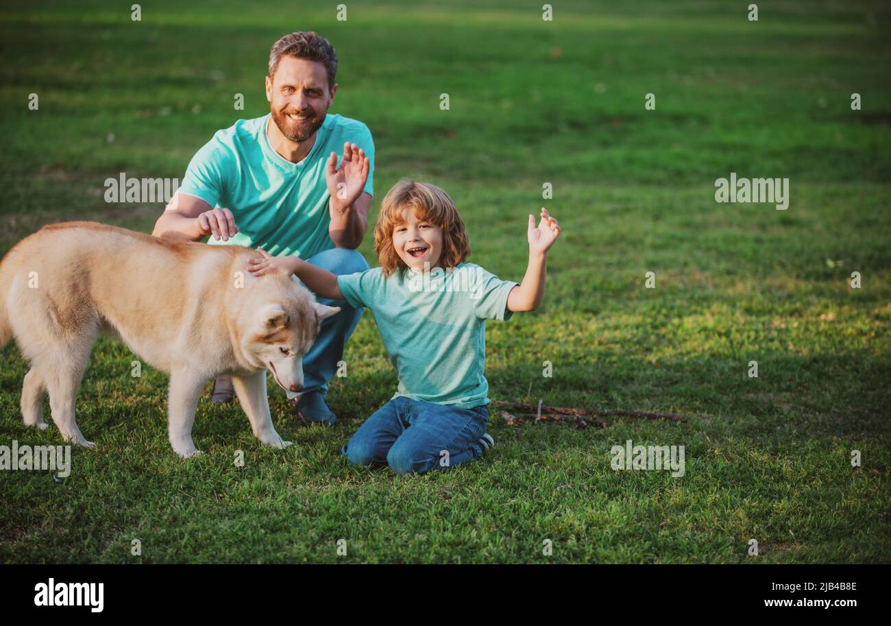 Happy father and son with dog at park. Weekend activity happy family ...