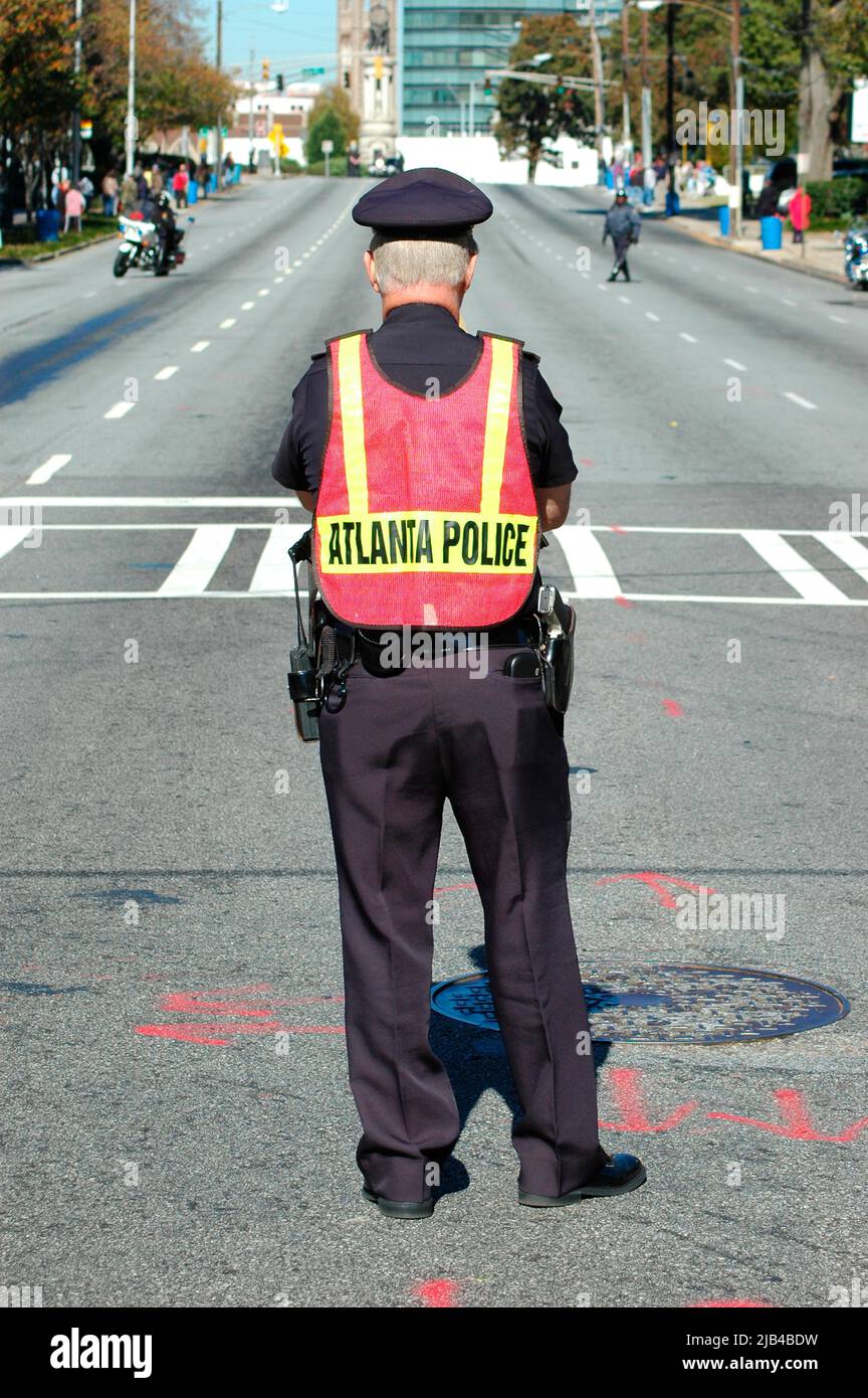 Police officer directing traffic to go or stop in Atlanta GA, white man ...