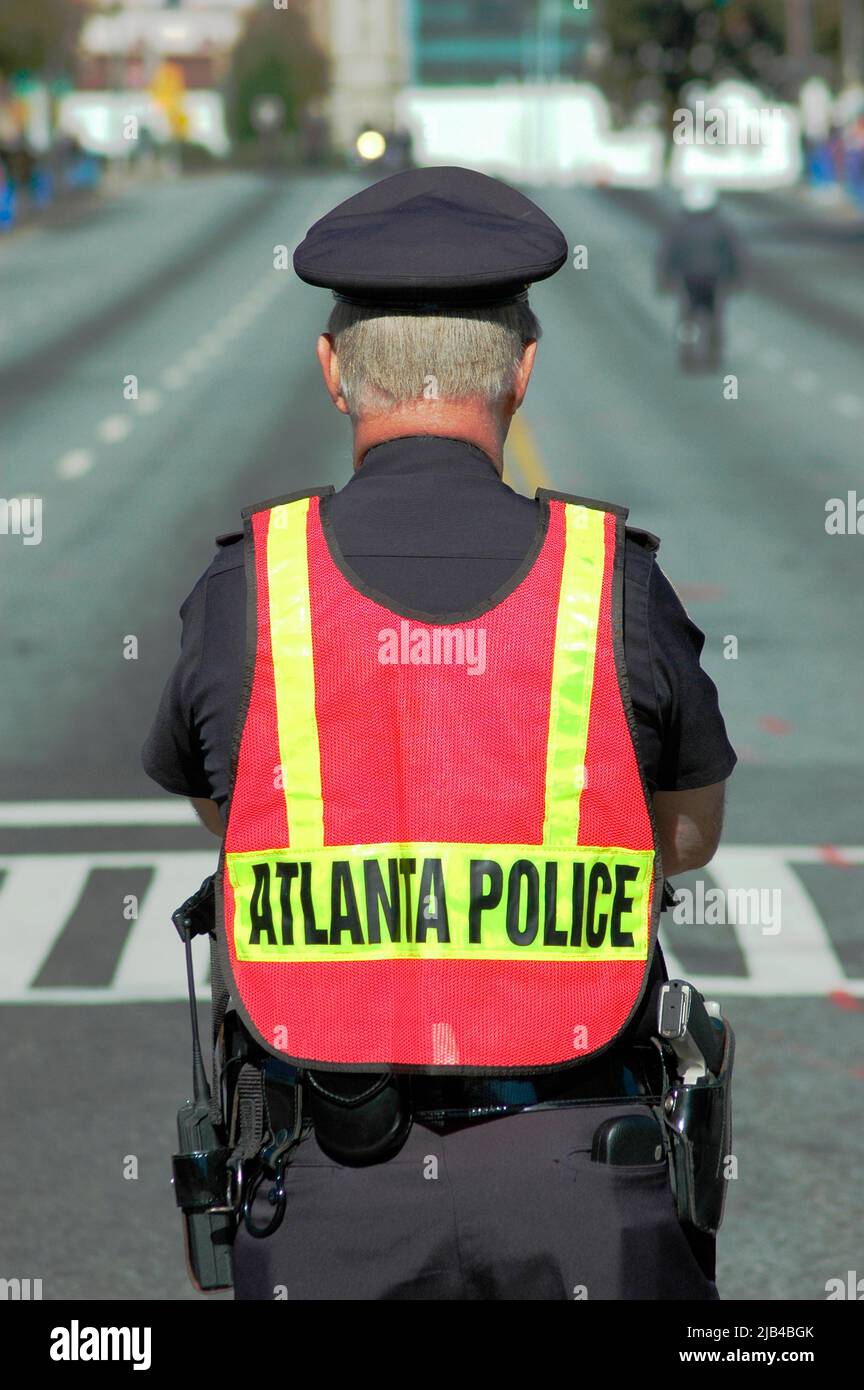 Police officer directing traffic to go or stop in Atlanta GA, white man ...