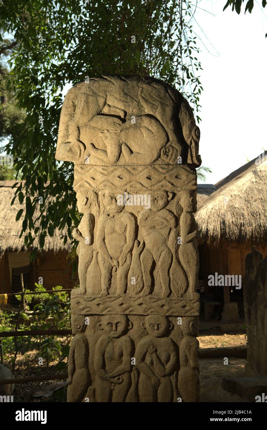 Stone carvings of human figures on a totem pole in traditional village ...
