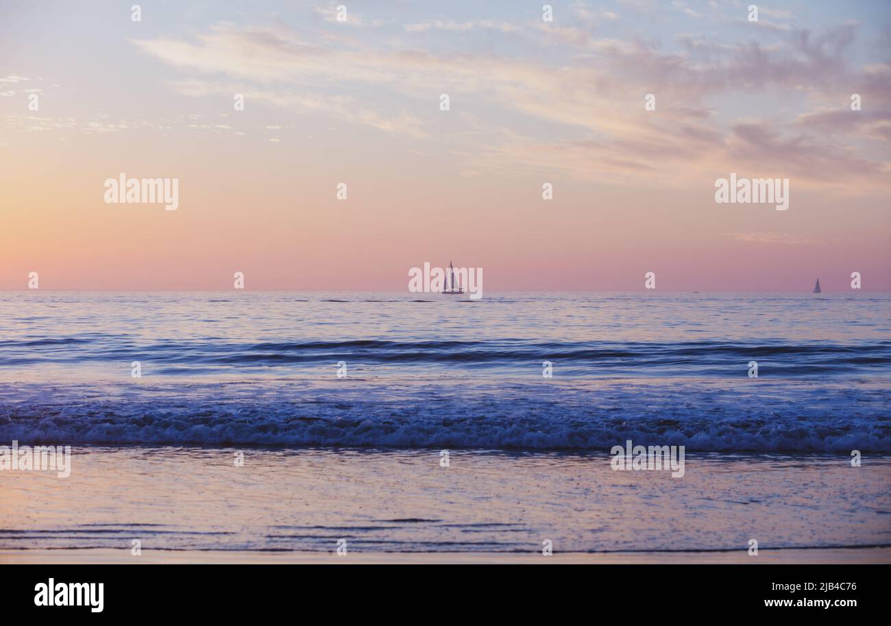 Calm sea with sunset sky and sun through the clouds over. Ocean and sky ...