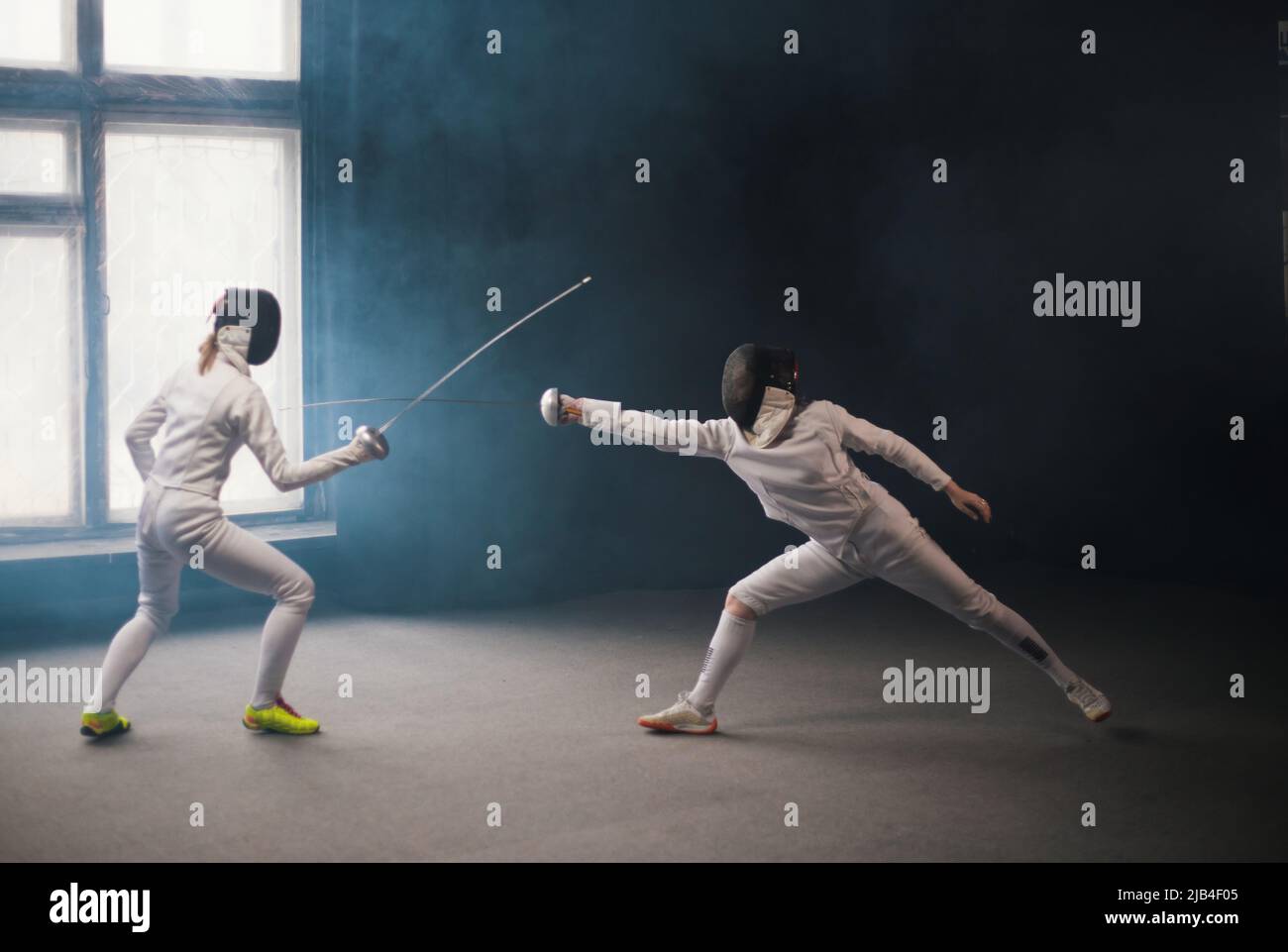 A fencing training - two women having a duel Stock Photo - Alamy