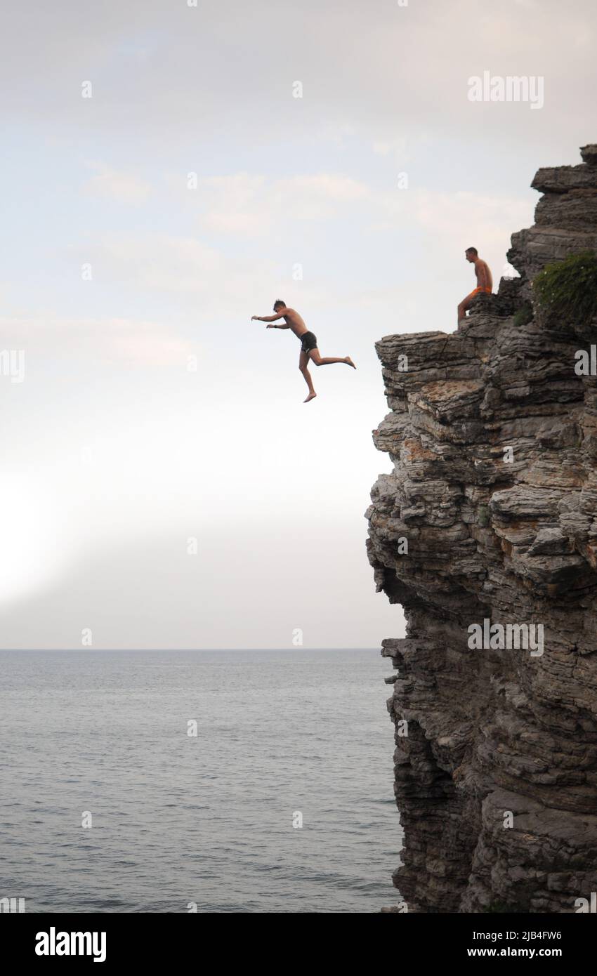 A man is jumping from a high cliff into the sea Stock Photo - Alamy