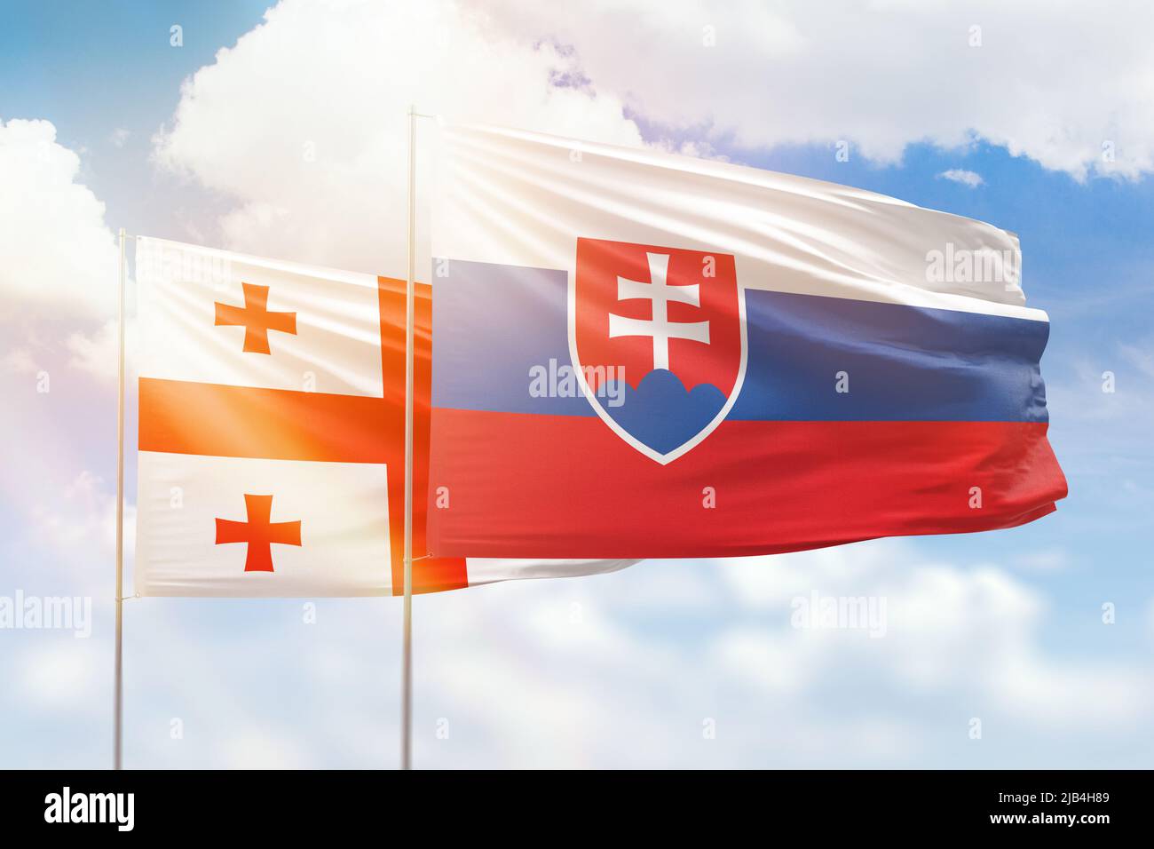 Sunny blue sky and flags of slovakia and georgia Stock Photo - Alamy