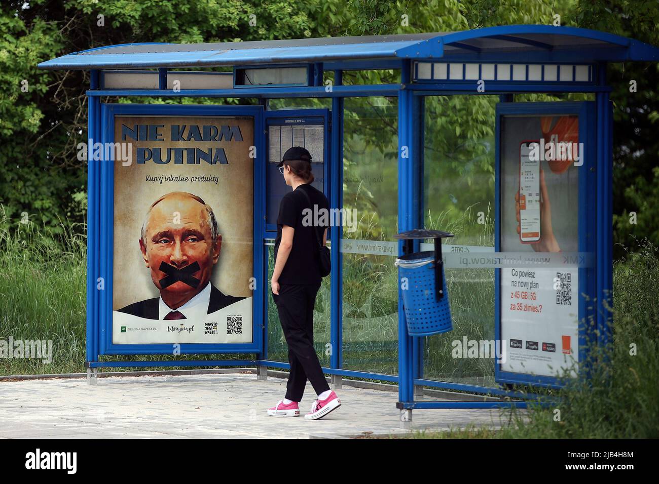A traveler looks at a poster showing Vladimir Putin with covered mouth ...