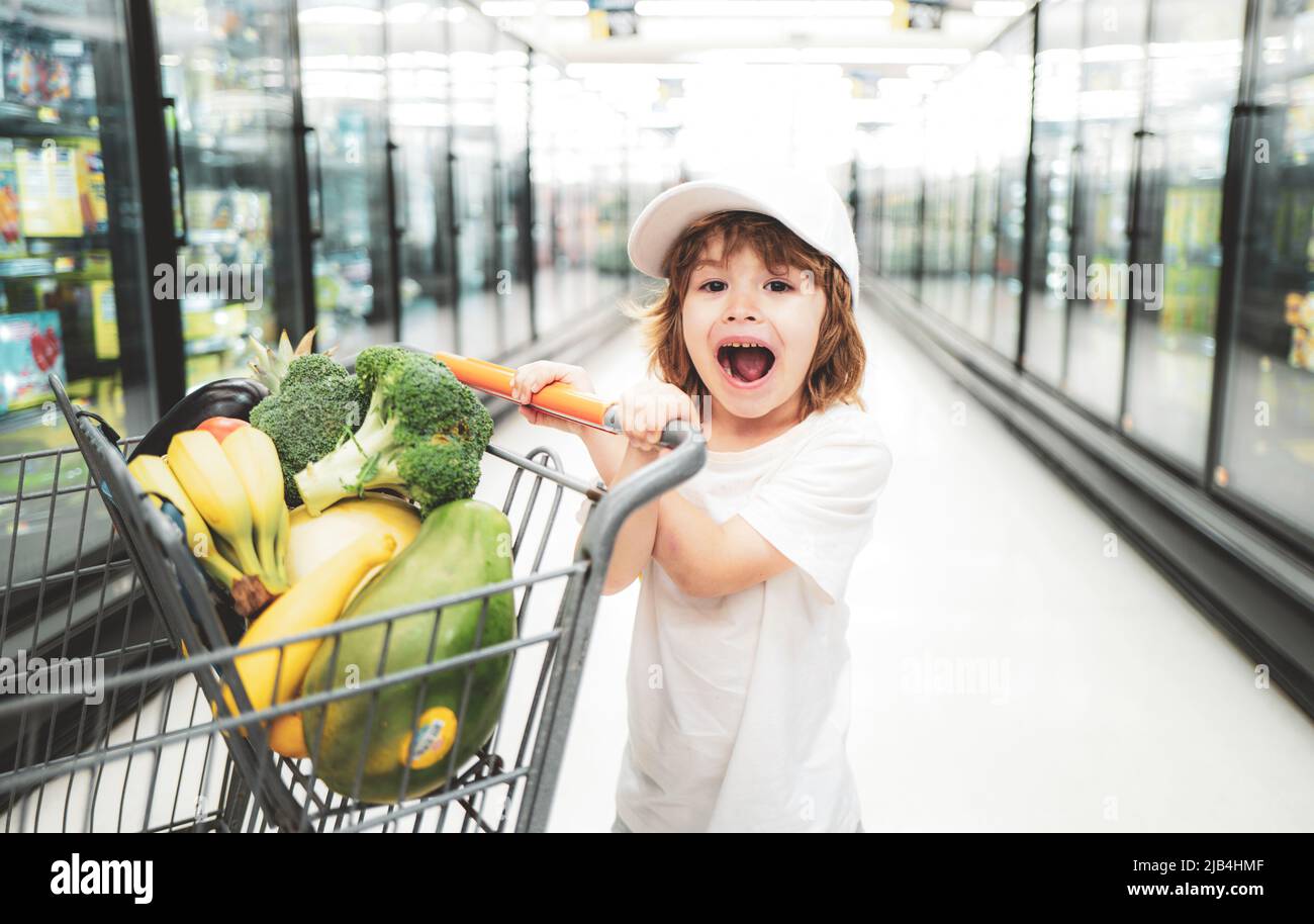 Toddler boy with shopping bag in supermarket. Child shopping in ...