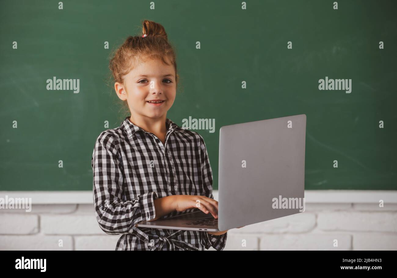 Cute little school kid girl study in a classroom. Online learning ...