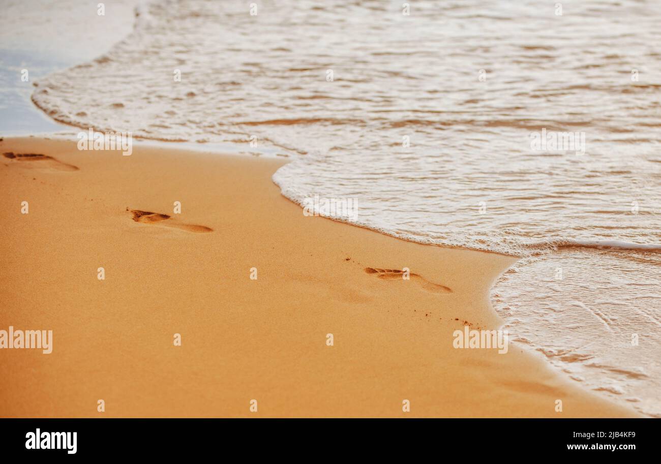 Footprints at golden sand, footsteps. Sea background, nature of ...