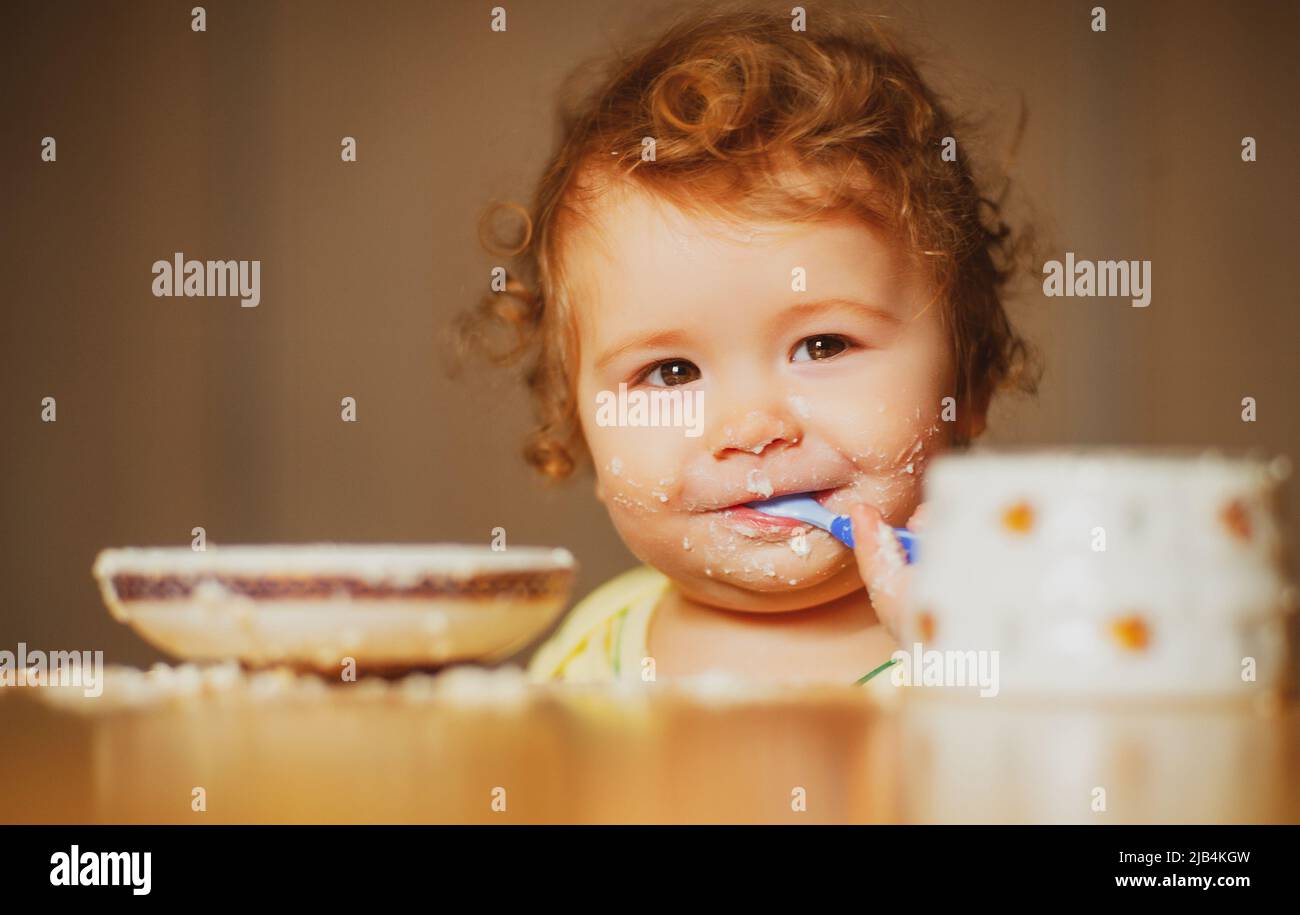 Cute little baby is being fed using spoon. Little child eating fruit ...